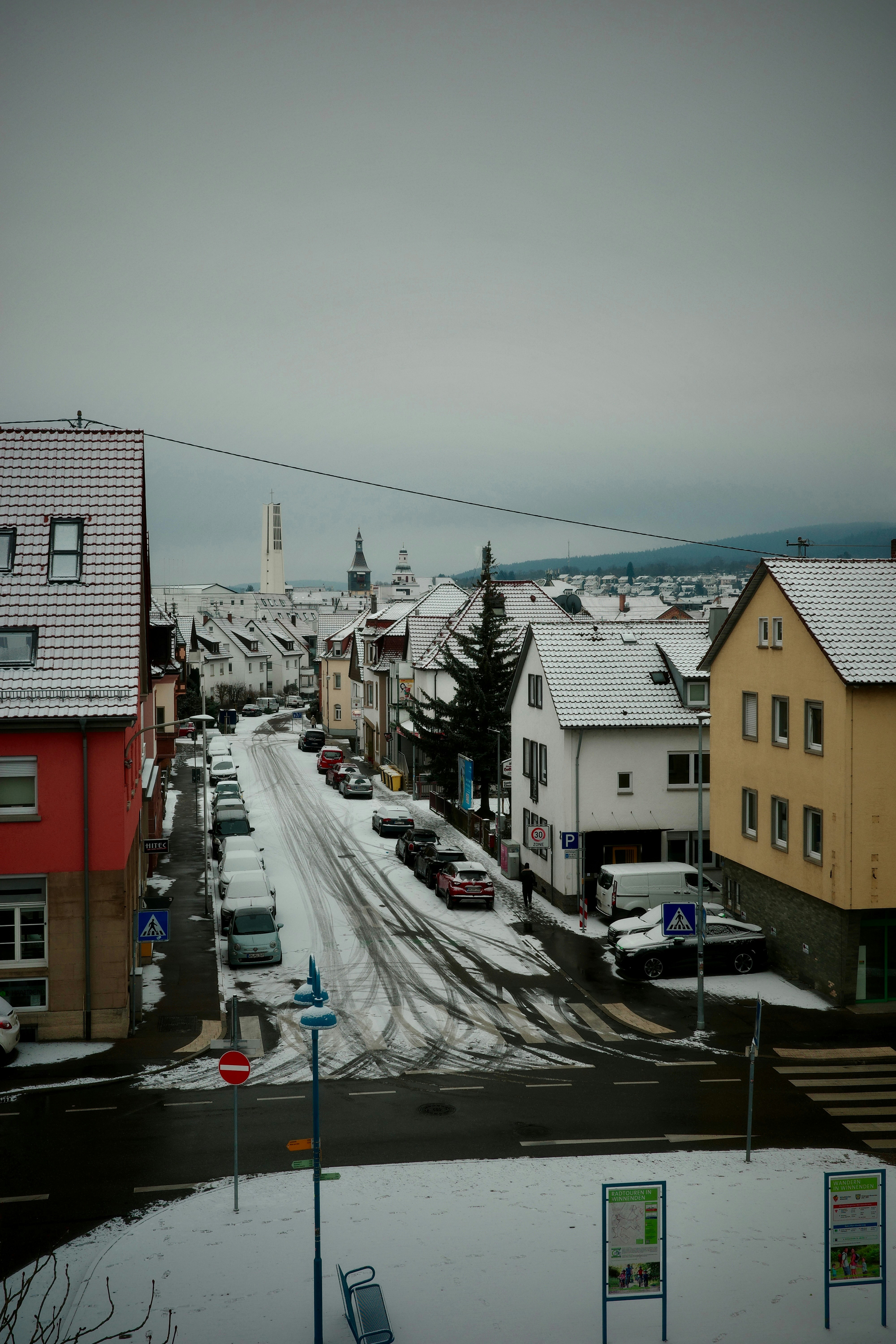 Snow-Blanketed Street Descends Toward a Quiet Town Core