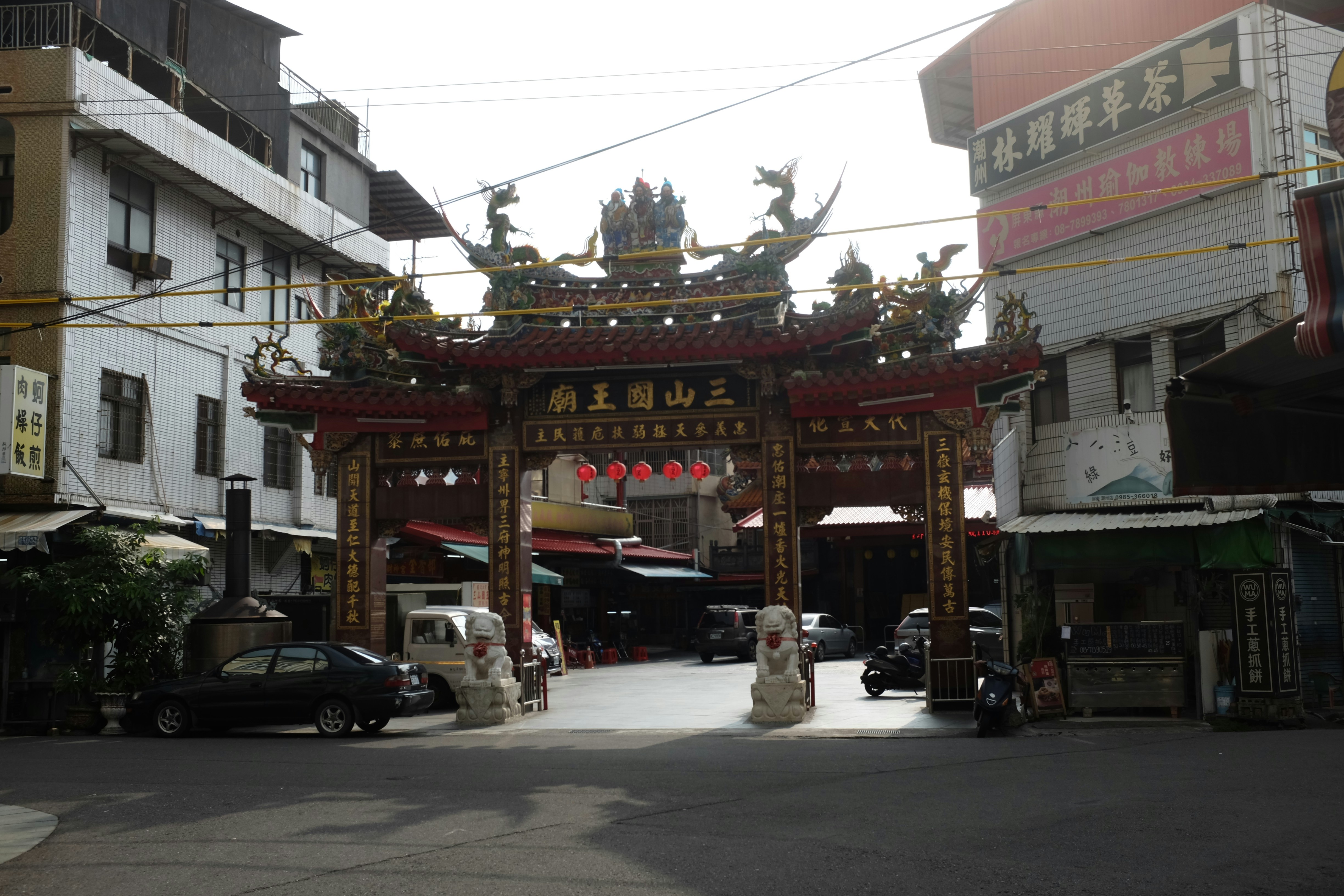 Temple Gate Under Painted Dragons: Street Corridor Framing a Cultural Threshold