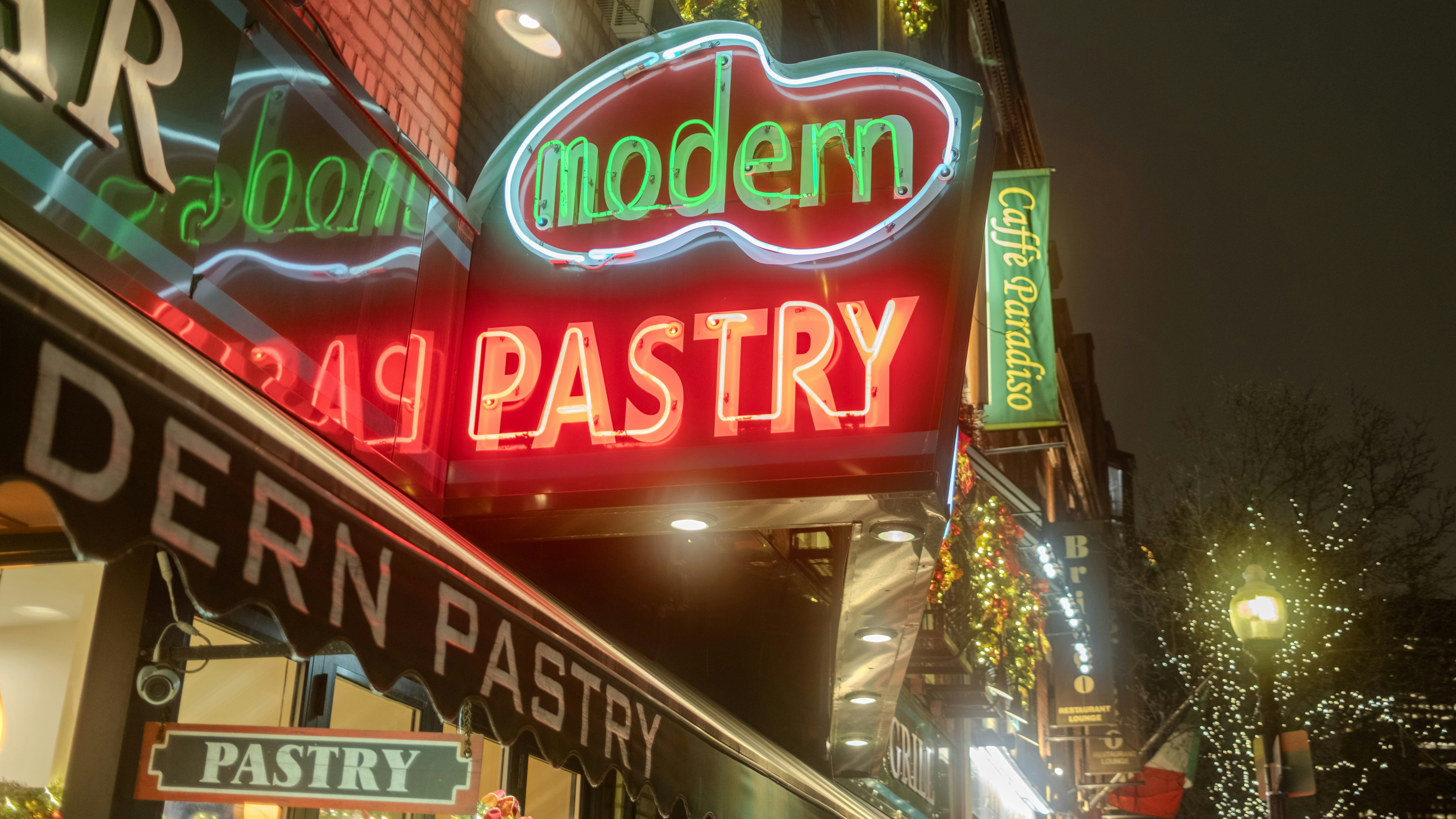 Neon Night Window: Glowing Pastry Signage and City Lights