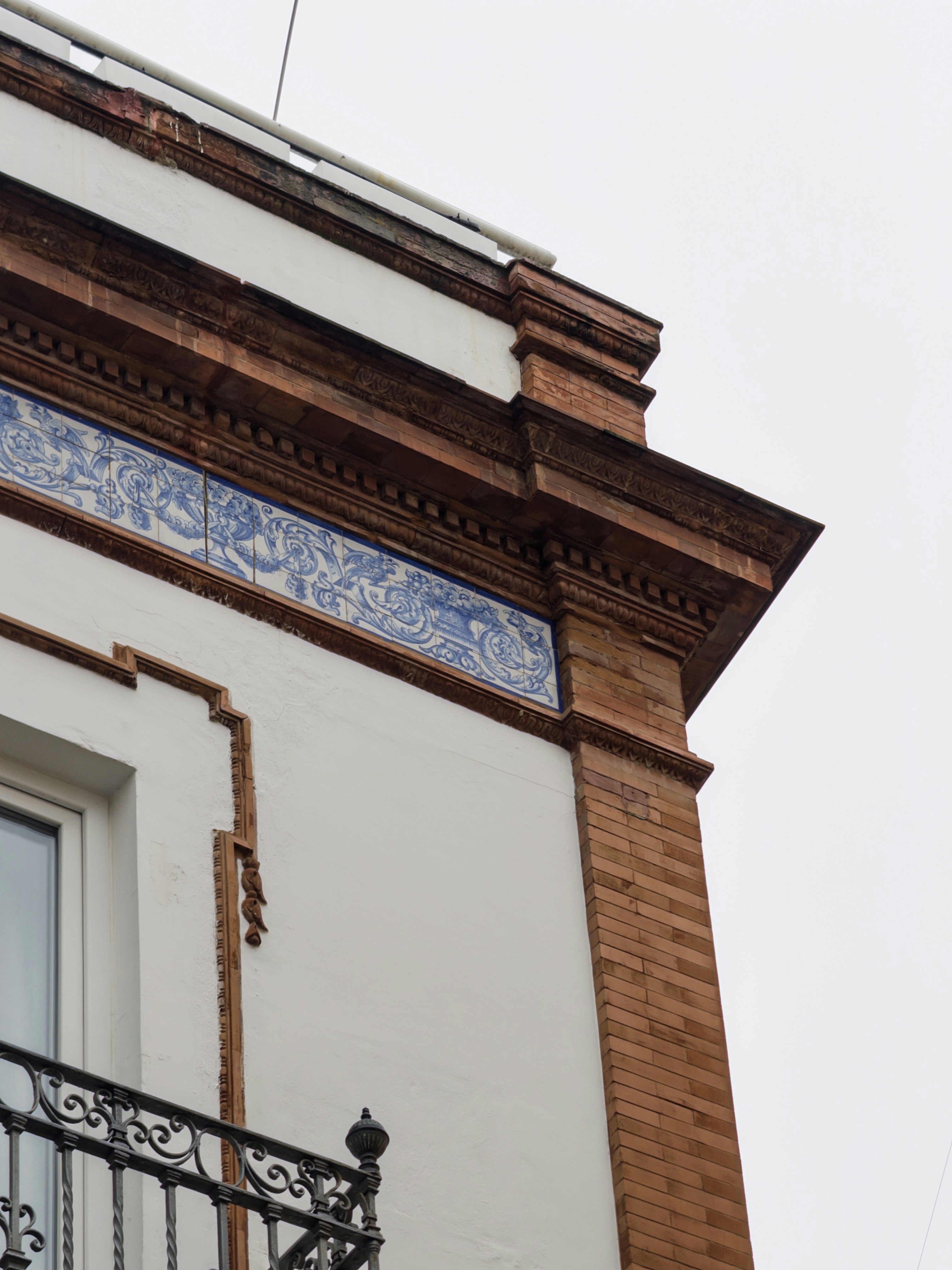 Corner of heritage: blue ceramic band atop brick trim