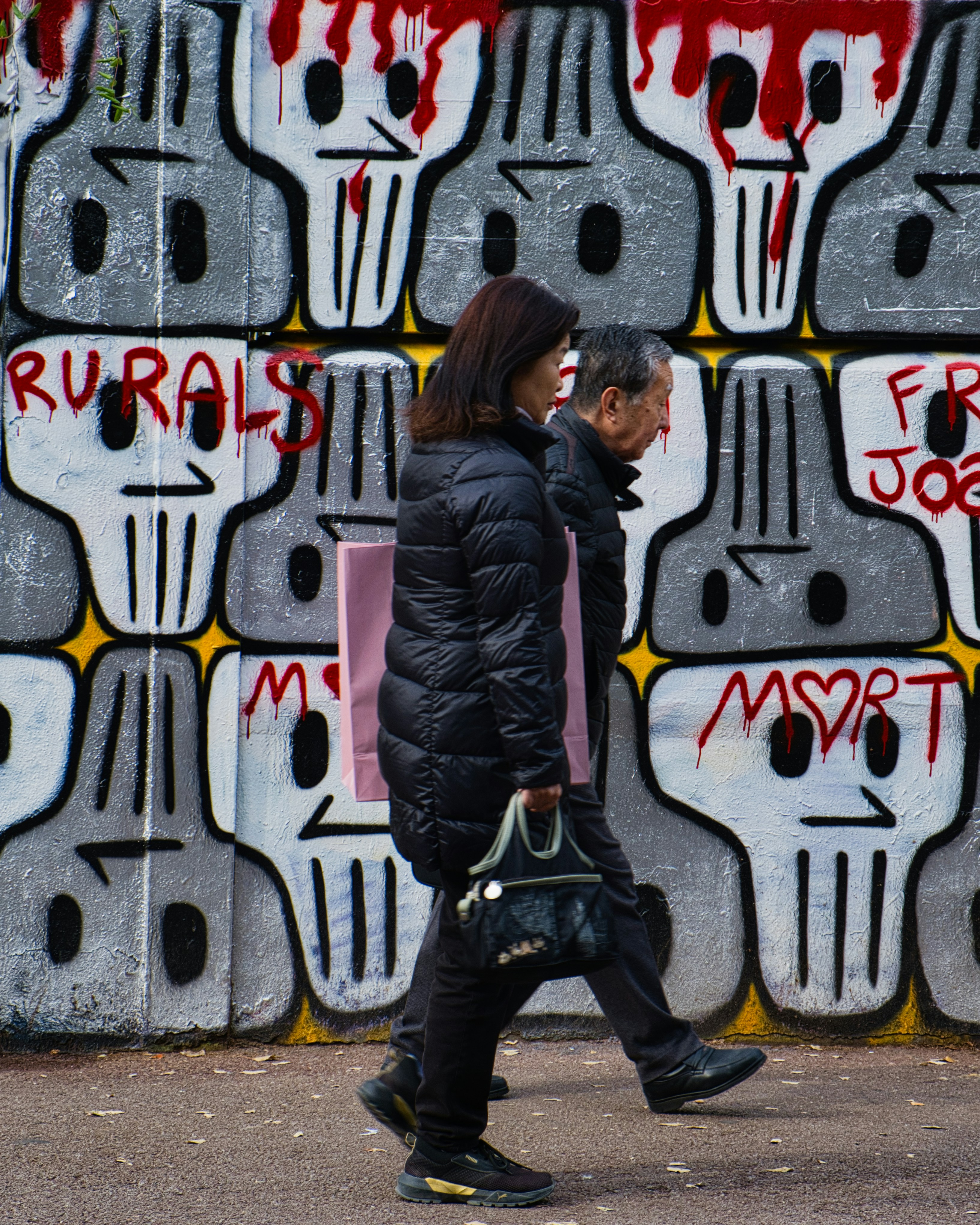 Passing Figures in Front of Repeated Grimace Graffiti