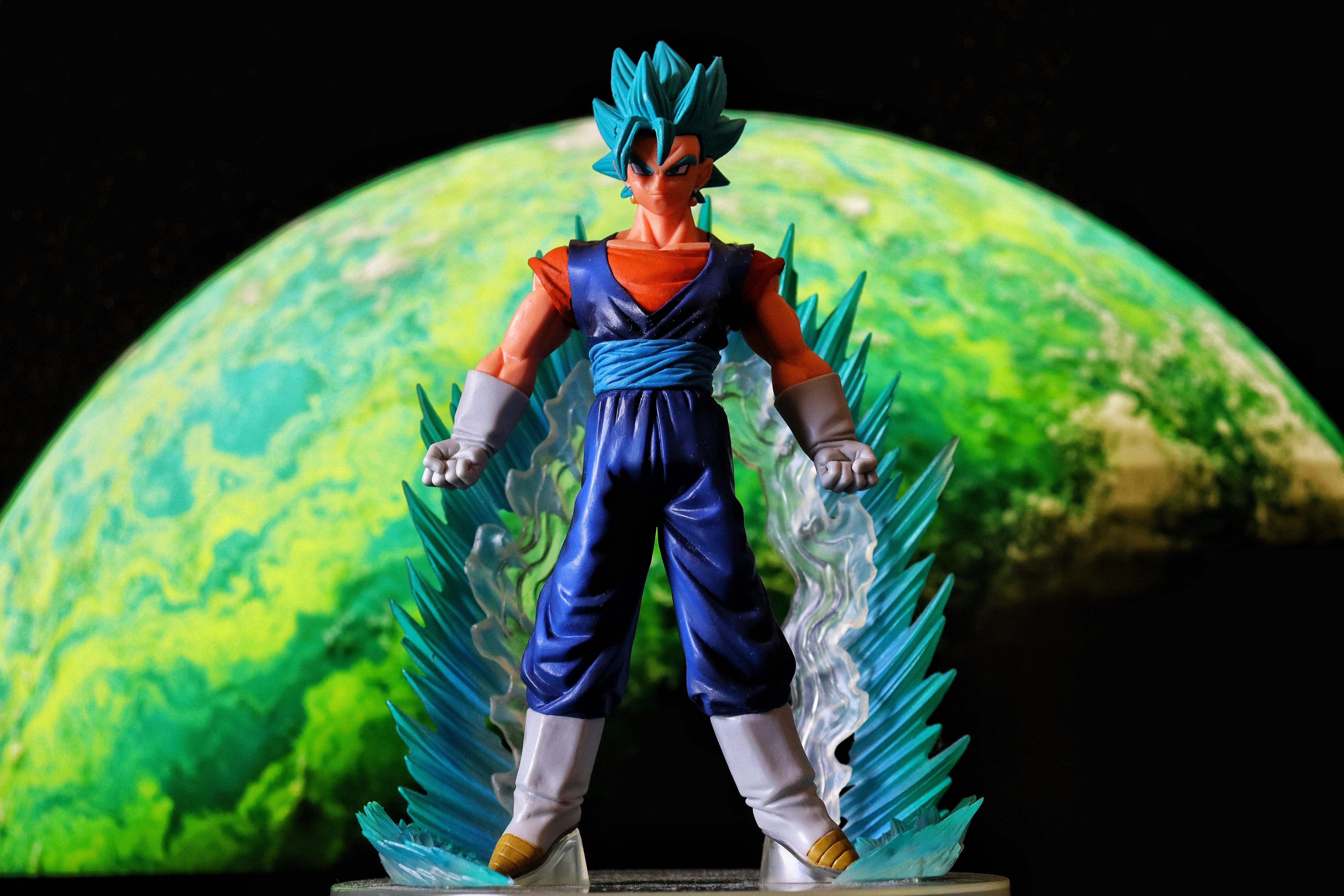 Blue-haired anime figure with glowing aura on planet background photo ...