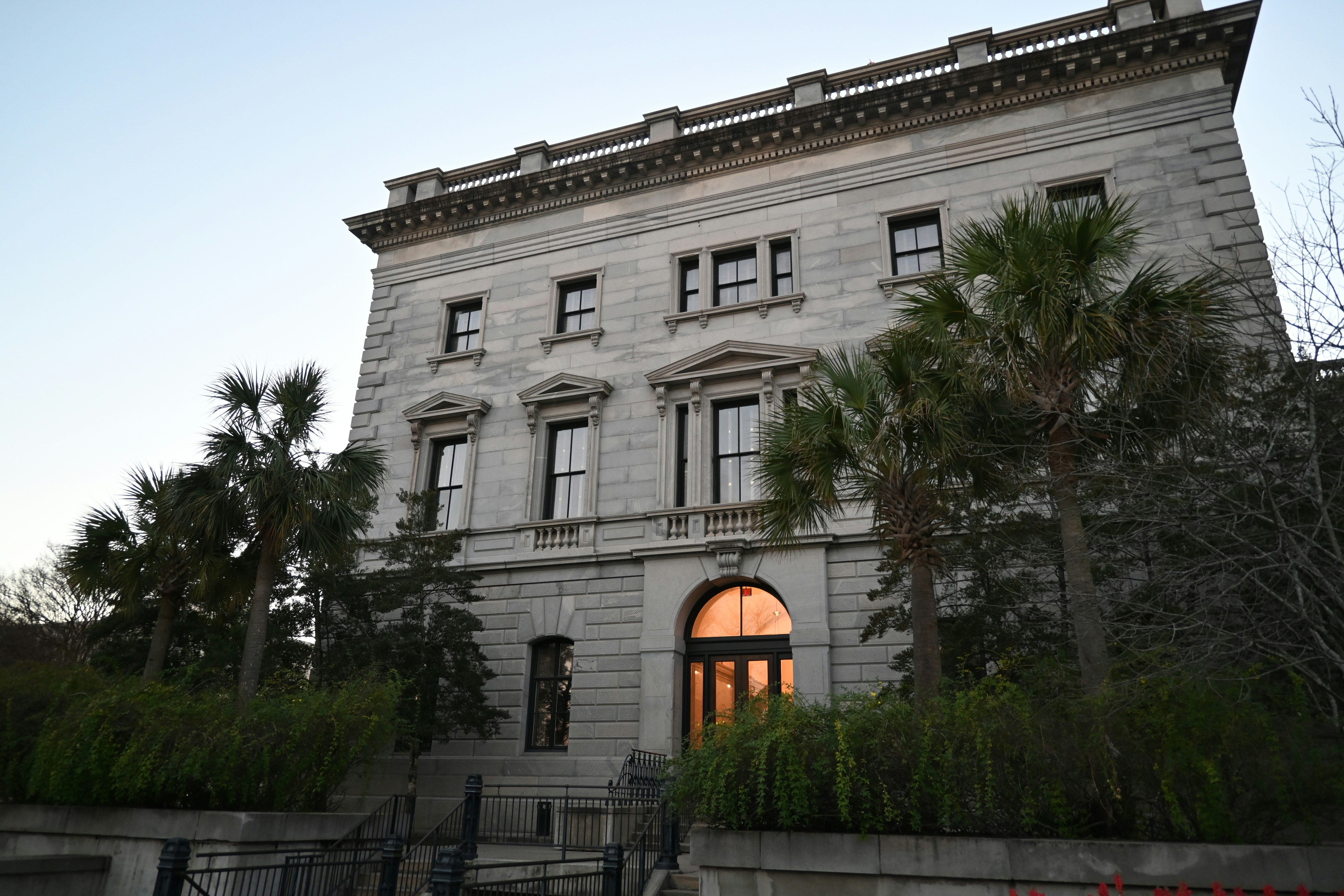 Heritage Facade glows through dusk with palm-framed arches