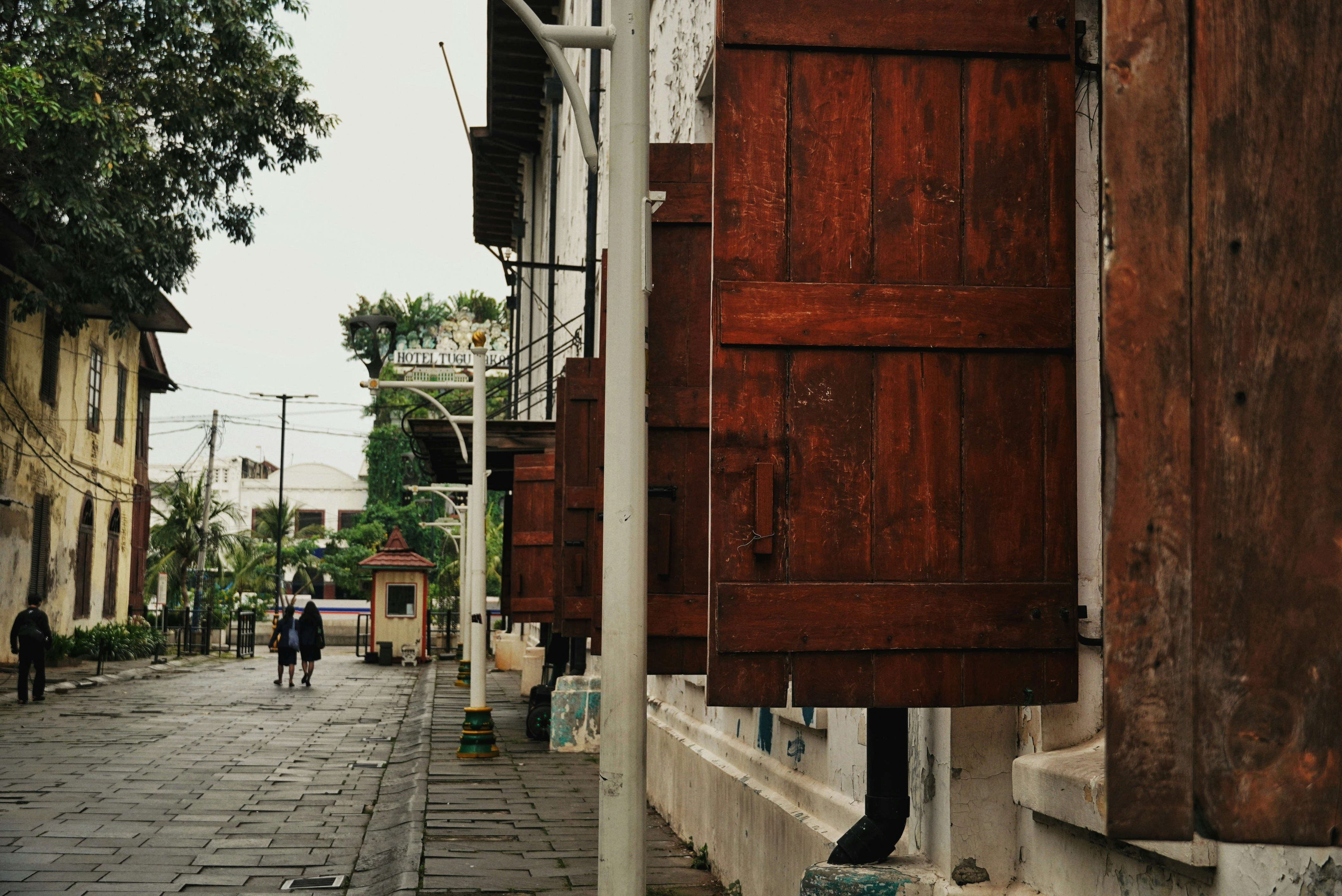 Weathered Wooden Shutter in a Quiet Street Corridor