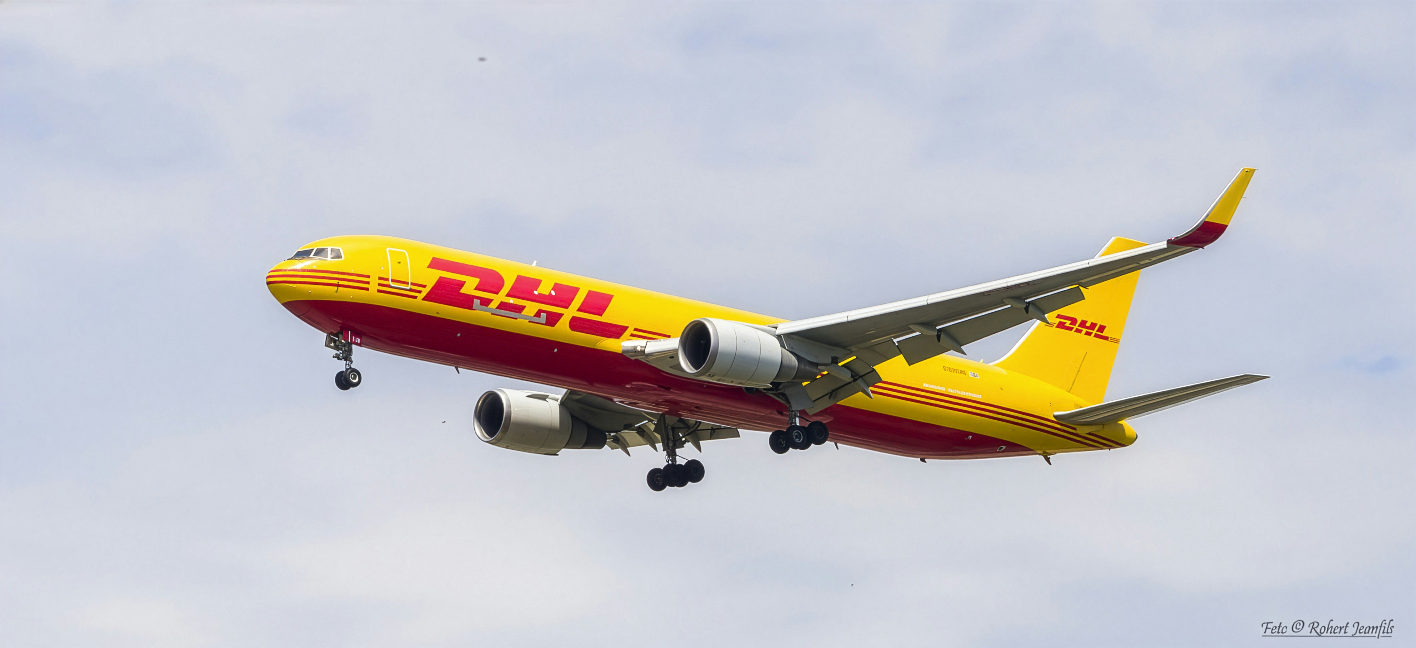 Yellow DHL Jet Soars Above Cloudscape