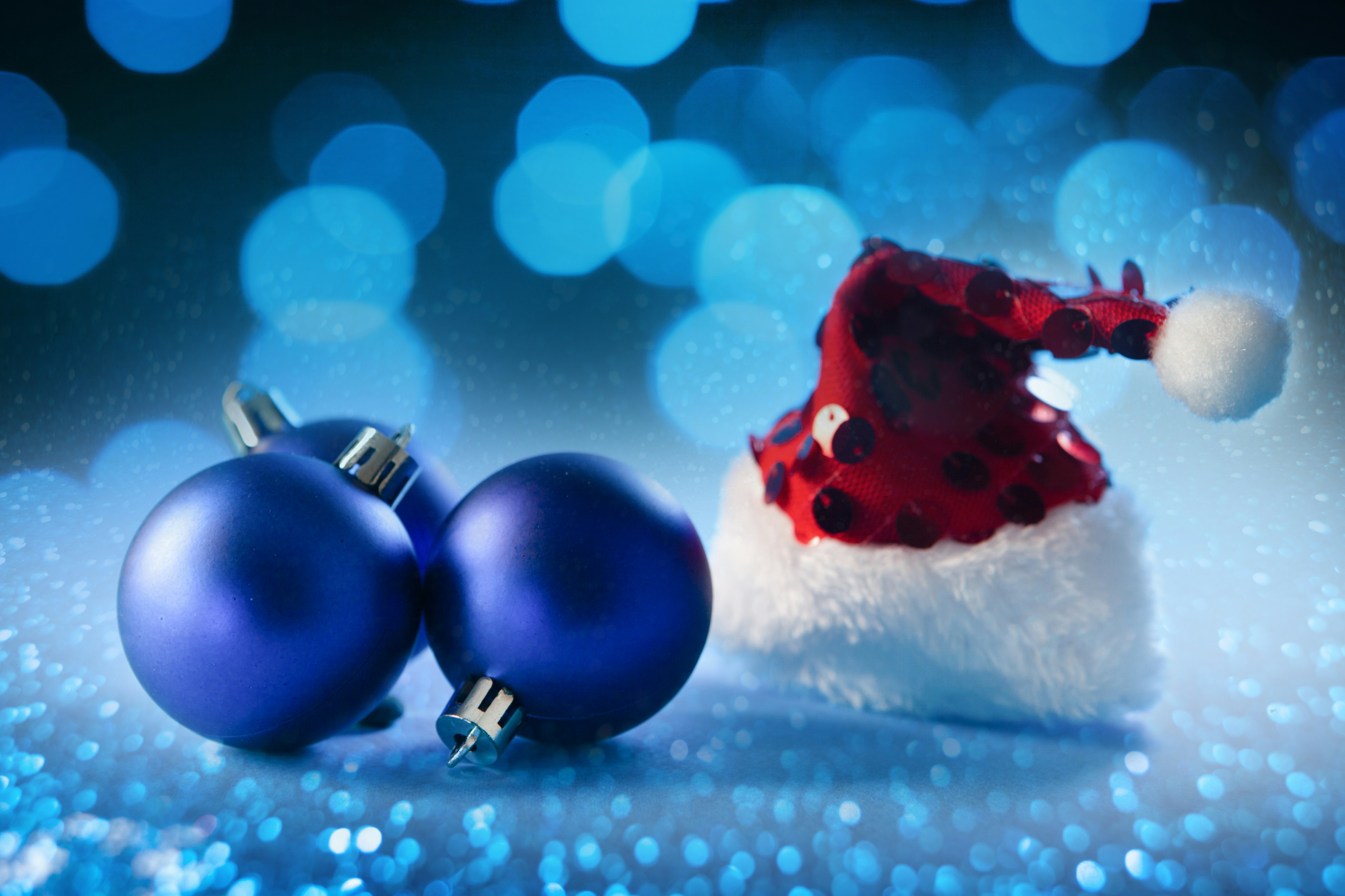 Blue Christmas Orbs and Santa Hat: A Festive Macro Moment