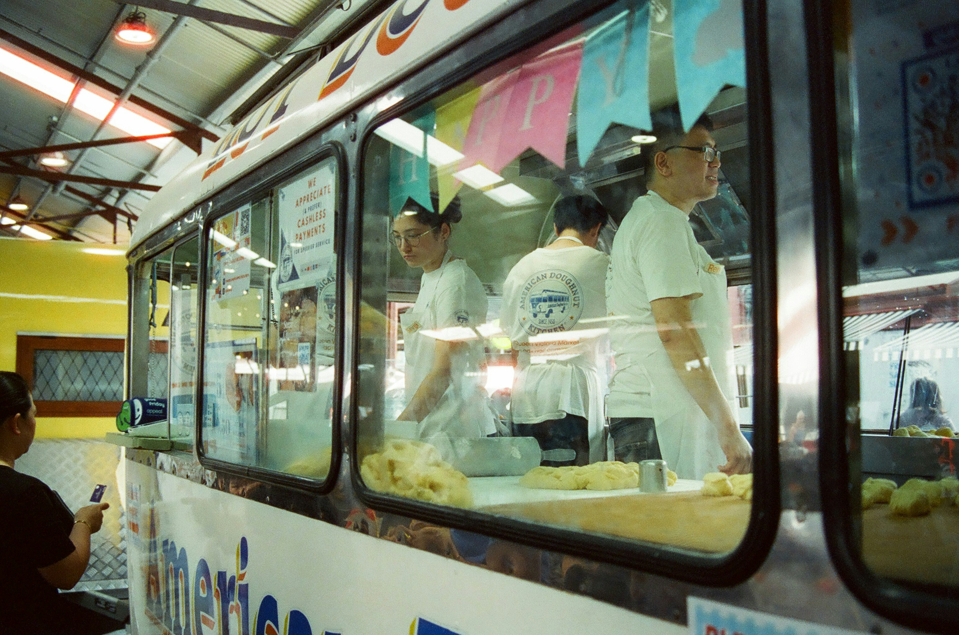 Workers preparing food behind a glass window. photo – Free Bakery Image ...
