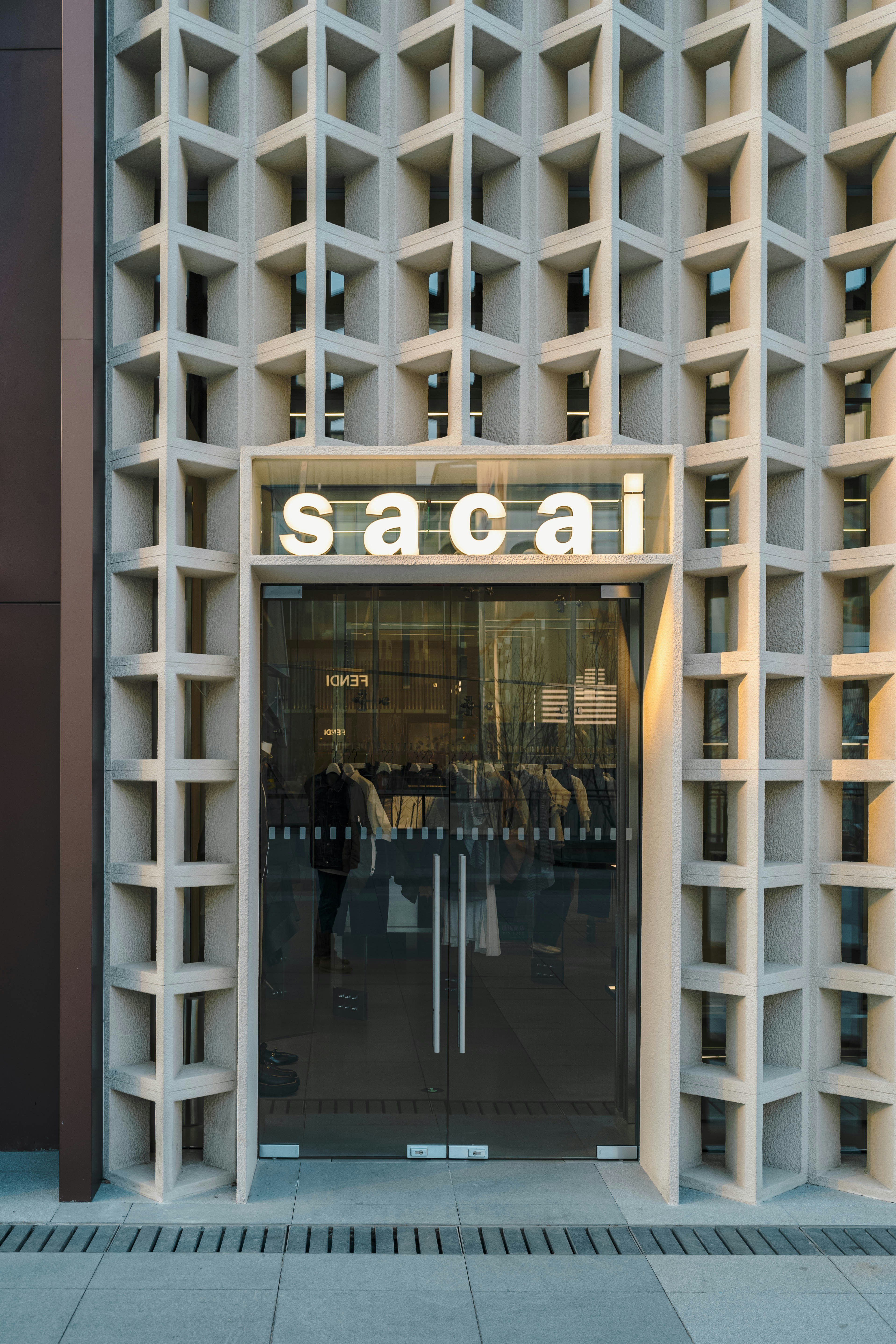 Facade Rhythm: Repeating Concrete Grids Framing a Storefront Lettering