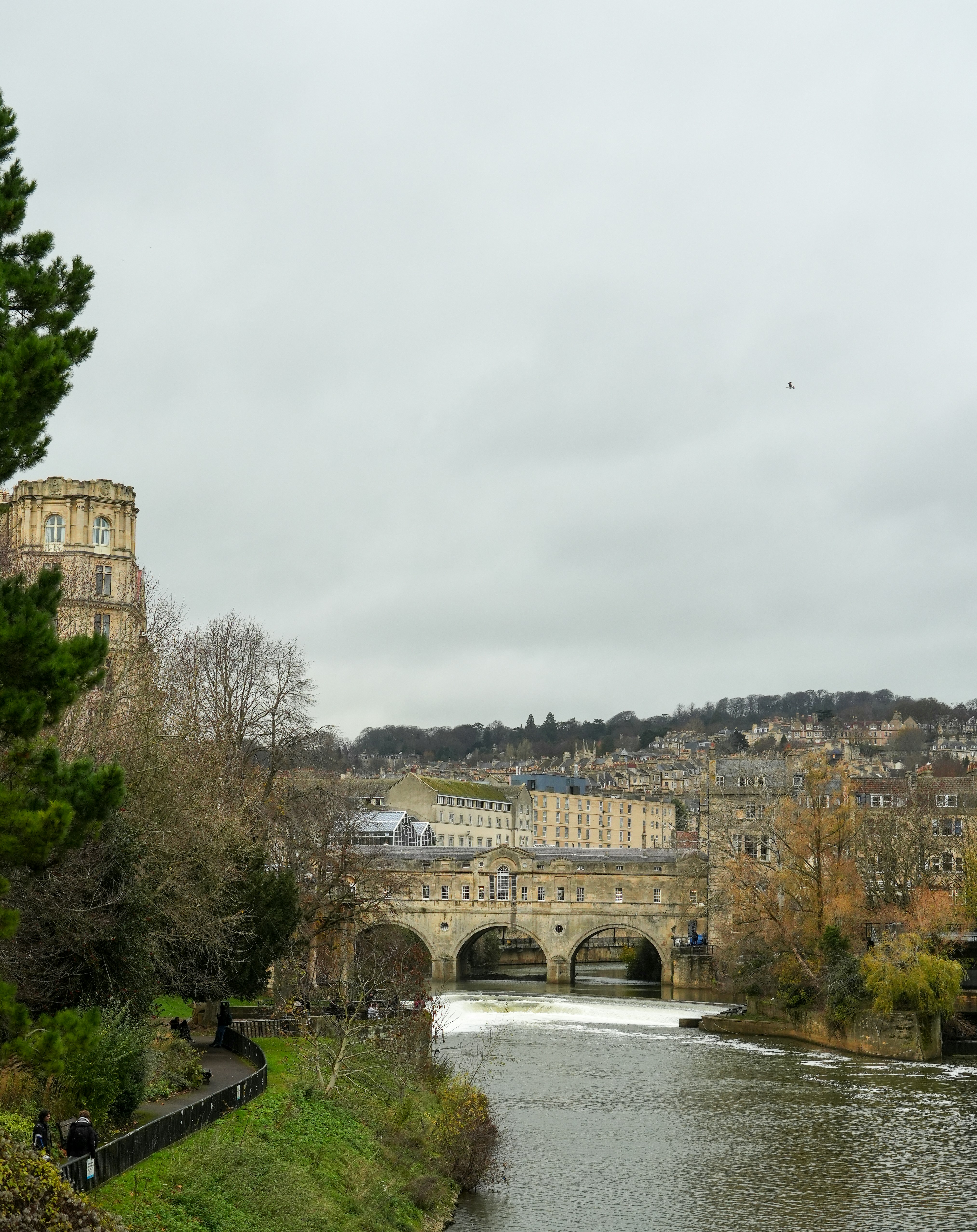 Arched Bridge and Riverside Village under a Gray Sky