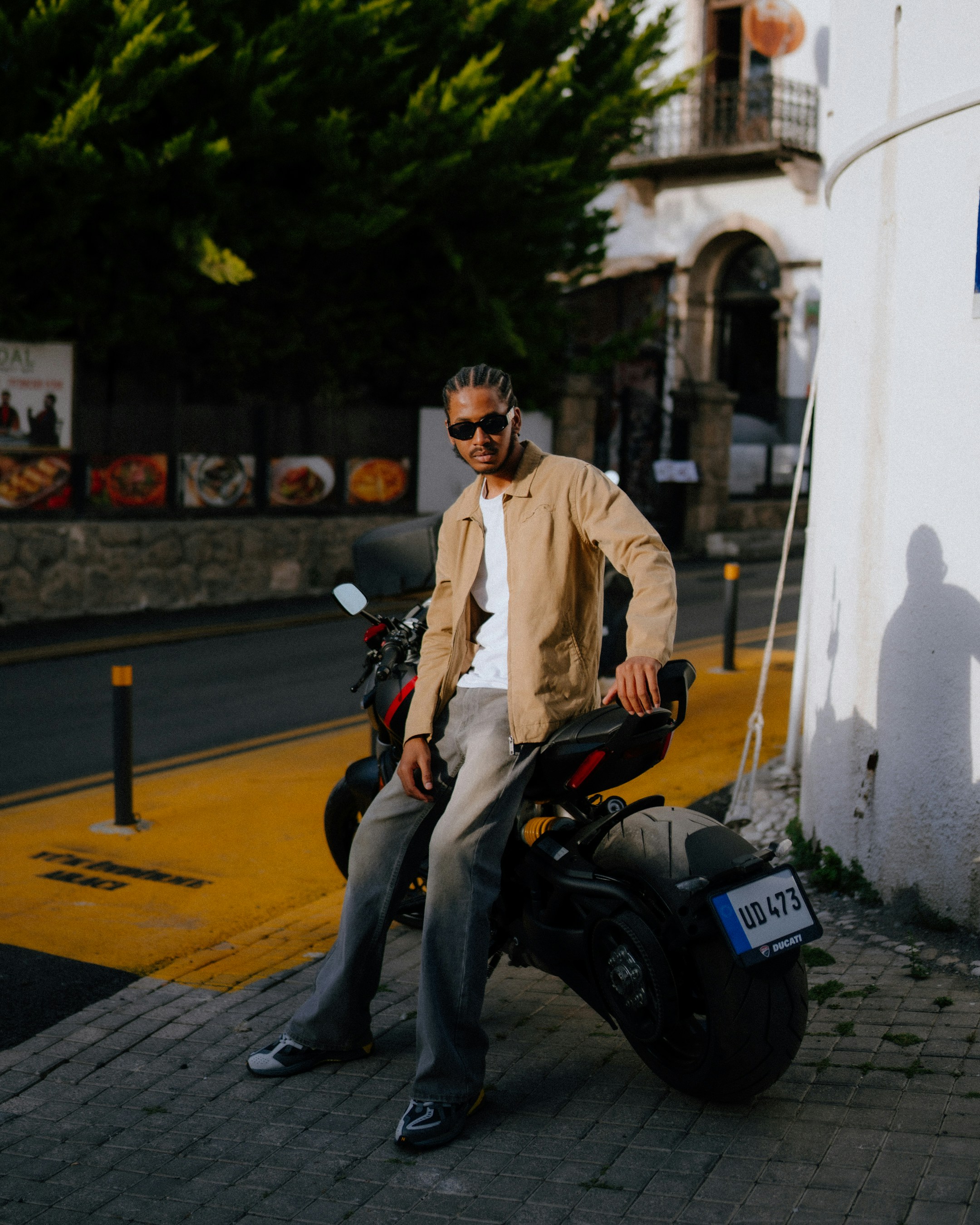 Casual Street Gaze: Rider in Tan Jacket Anchors a Quiet City Moment