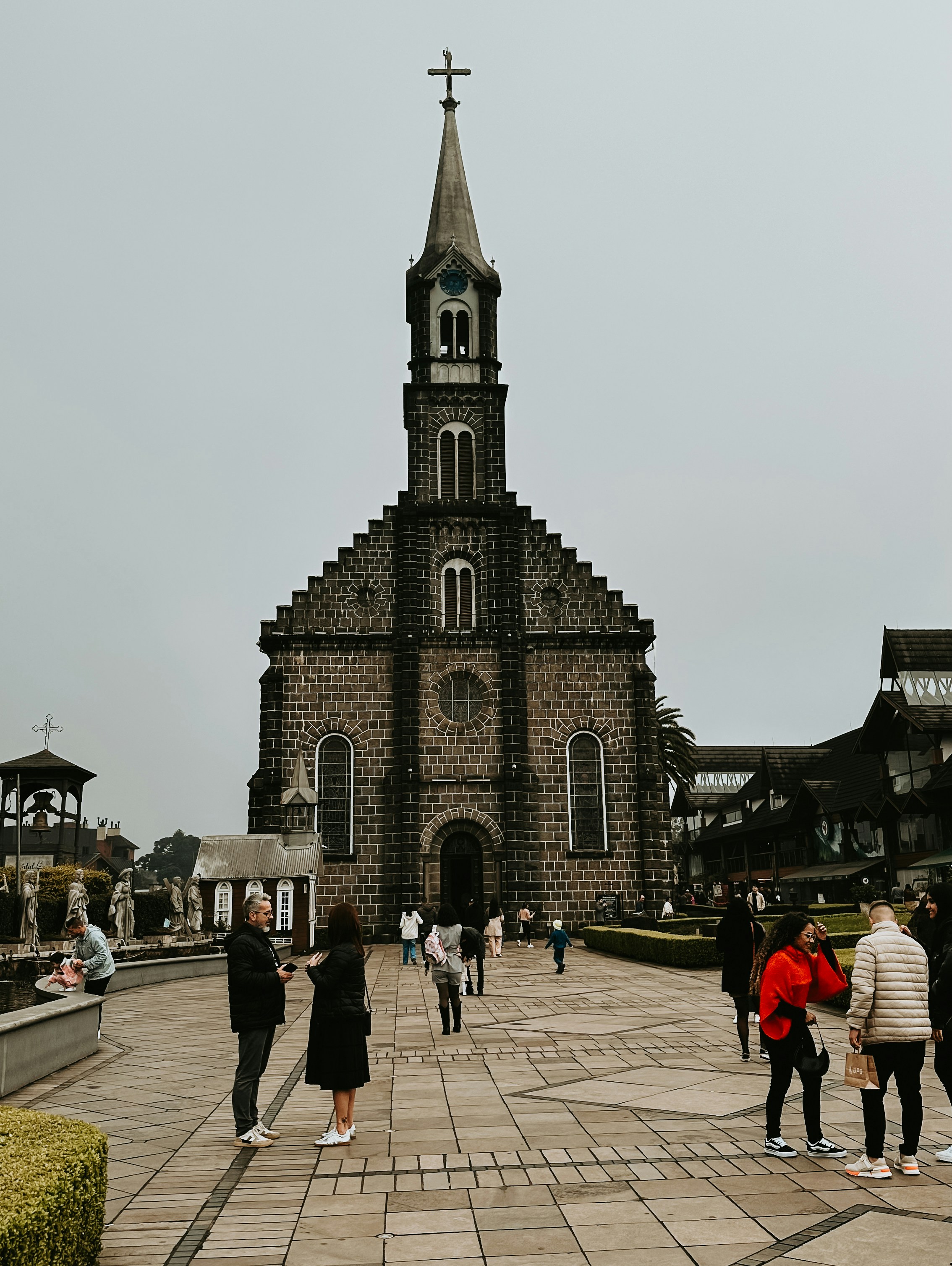 Stone Church of stepped gables under a pale sky, bustling plaza full of visitors
