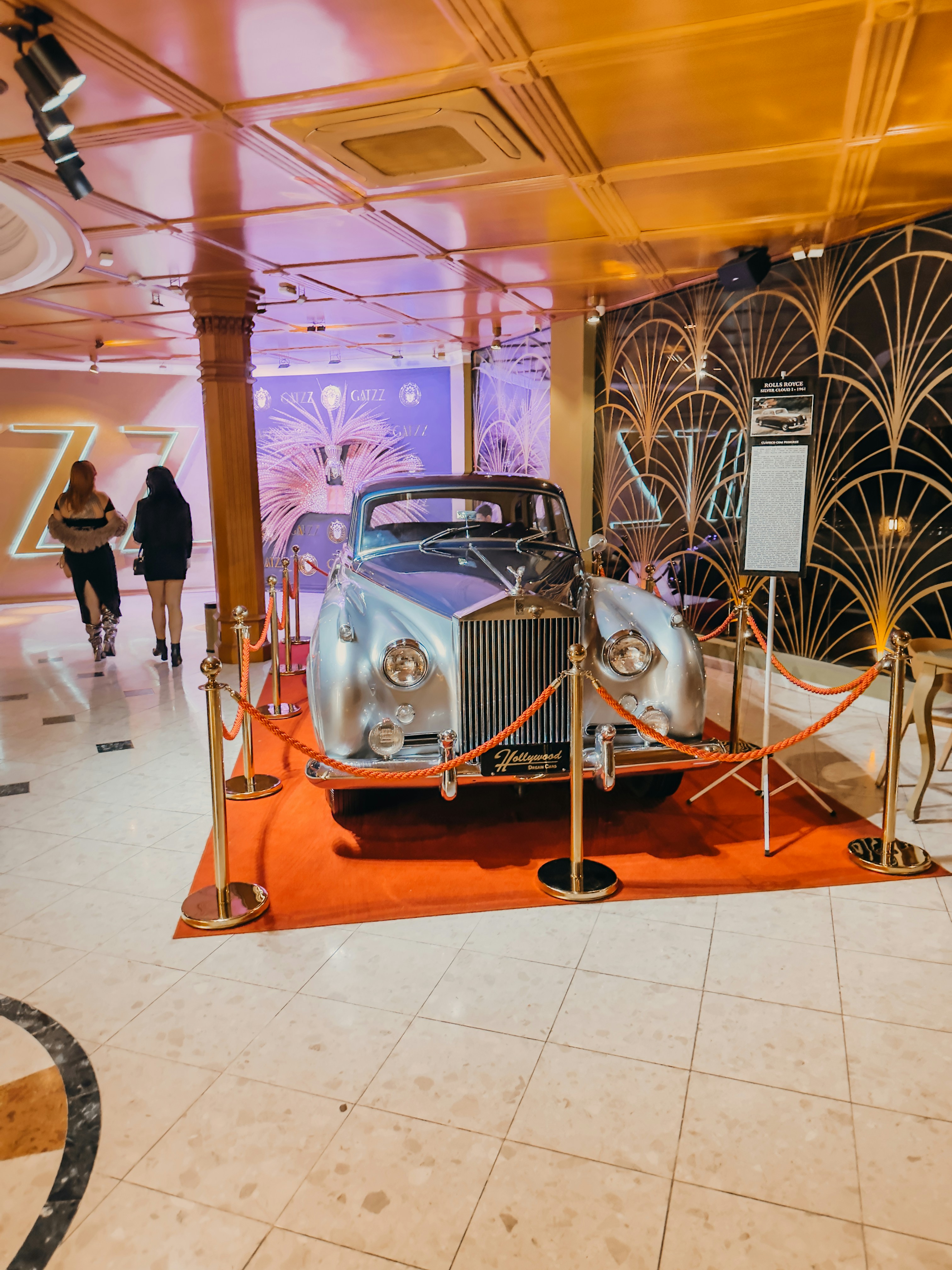 Vintage rolls-royce displayed on a red carpet.