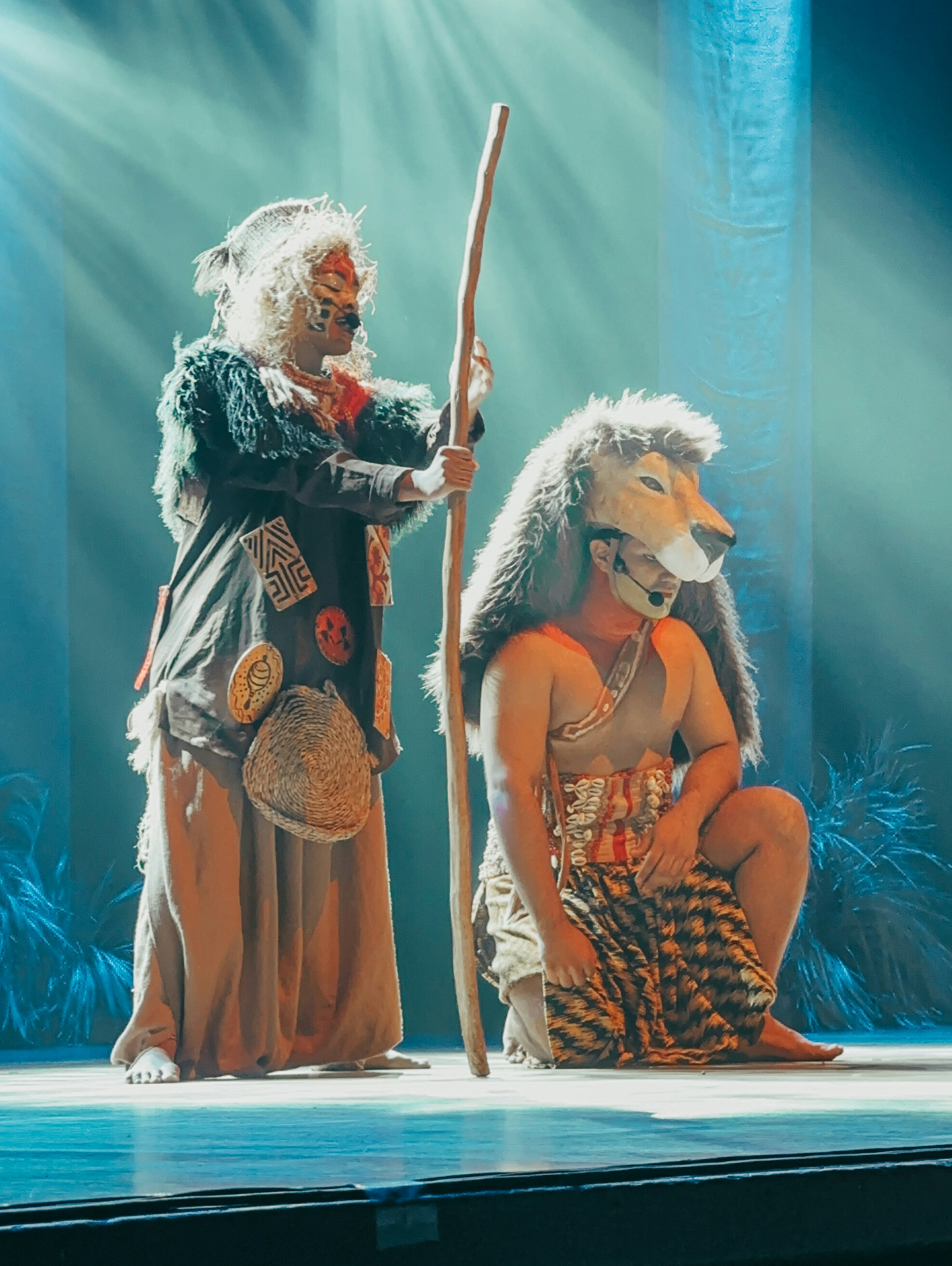 Stage Masks: Keeper and Wolf Attire Under Ethereal Spotlight