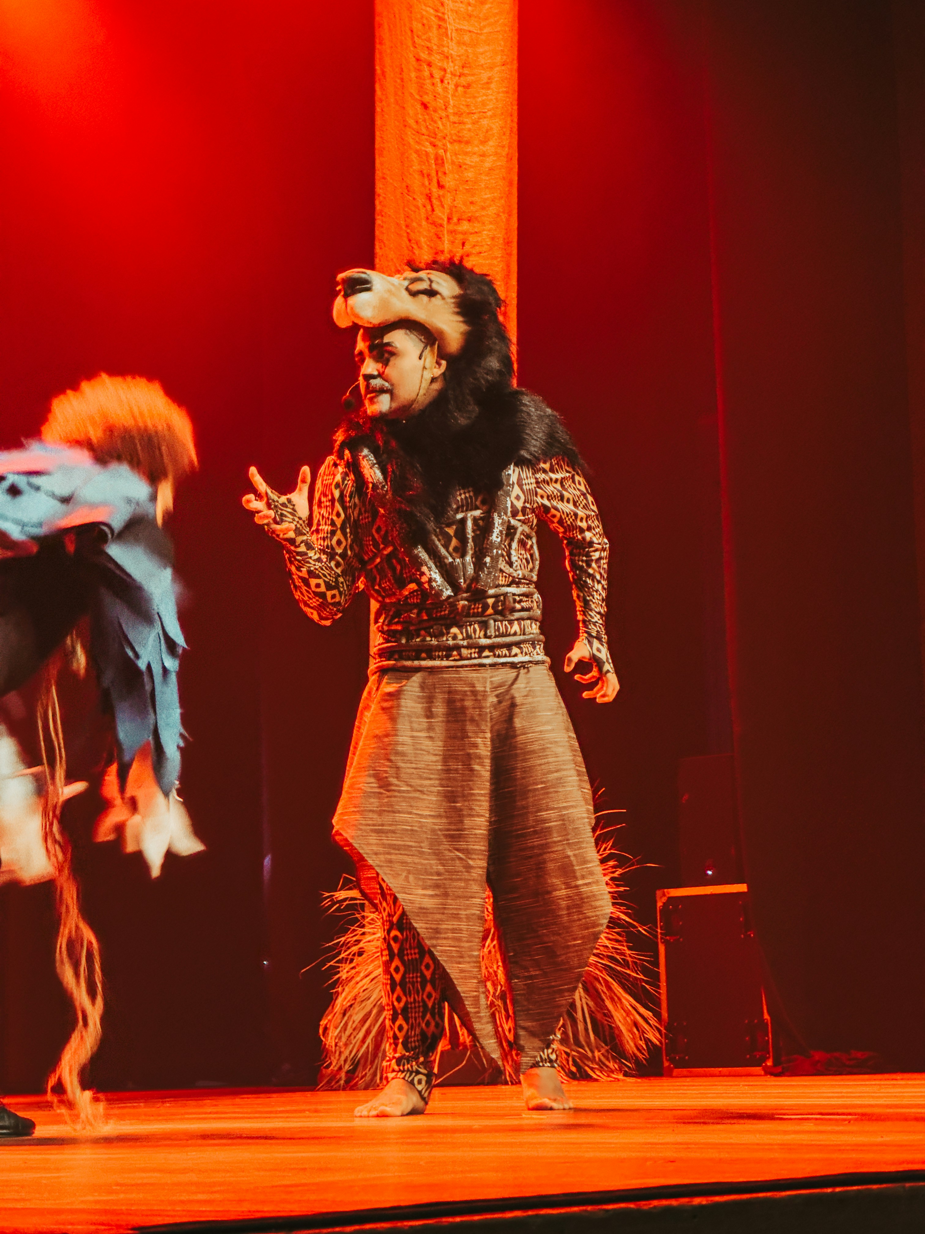 Beast on Stage: A Lion Mask and Fiery Spotlight