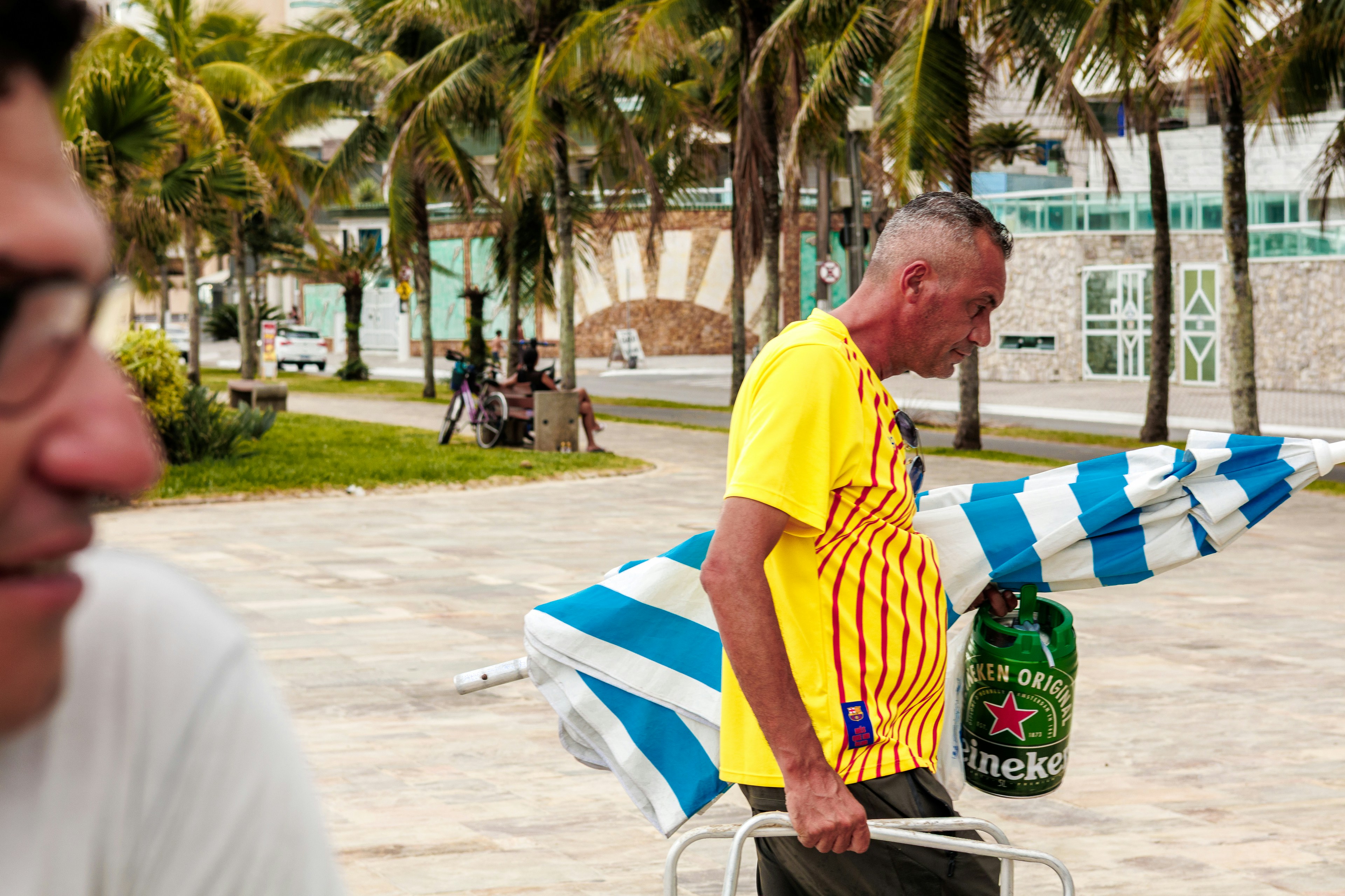 Sunlit Strand Vendor: A Moment by the Palm-Shaded Boardwalk