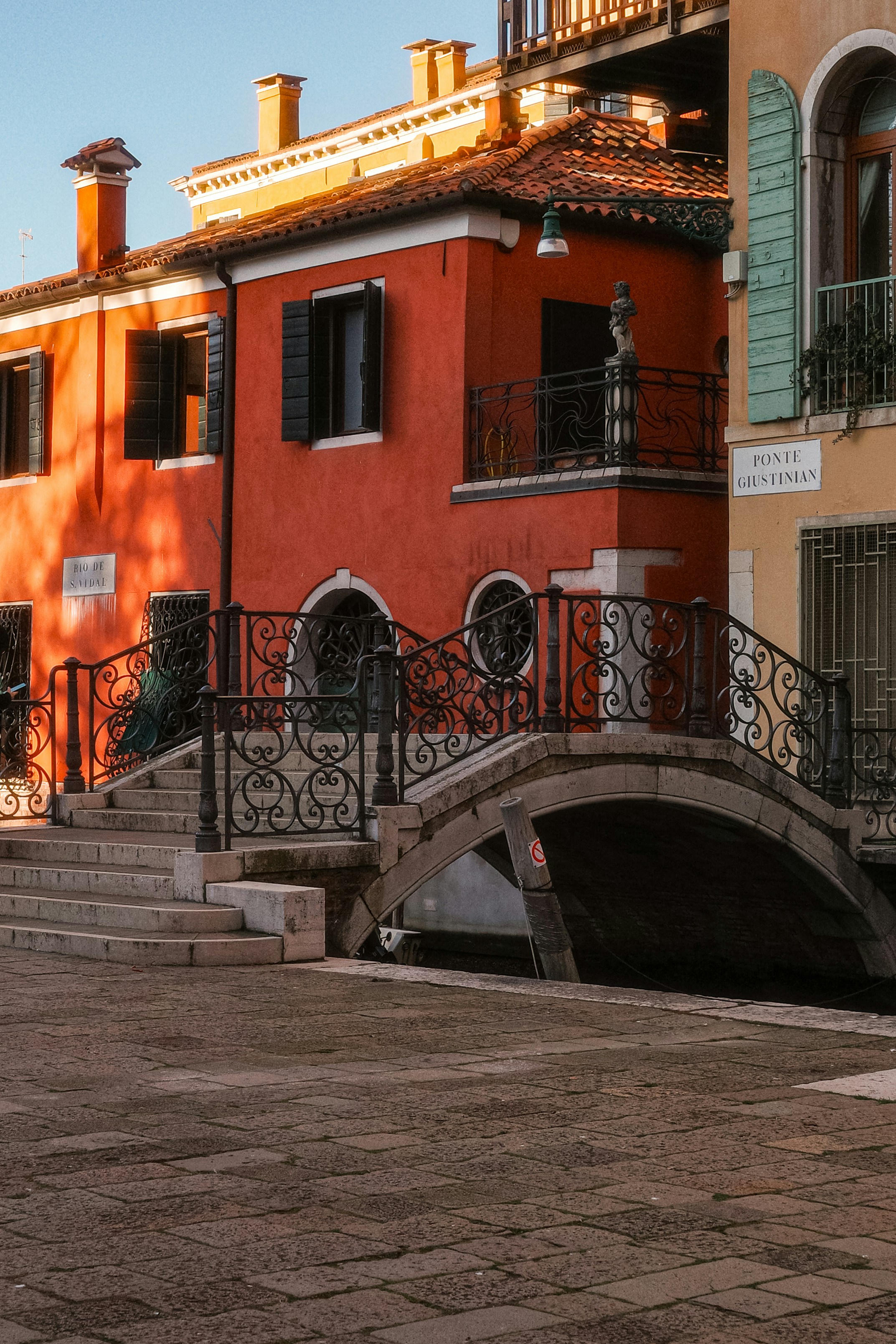 Sunlit Venetian Facade Overarched by a Stone Bridge