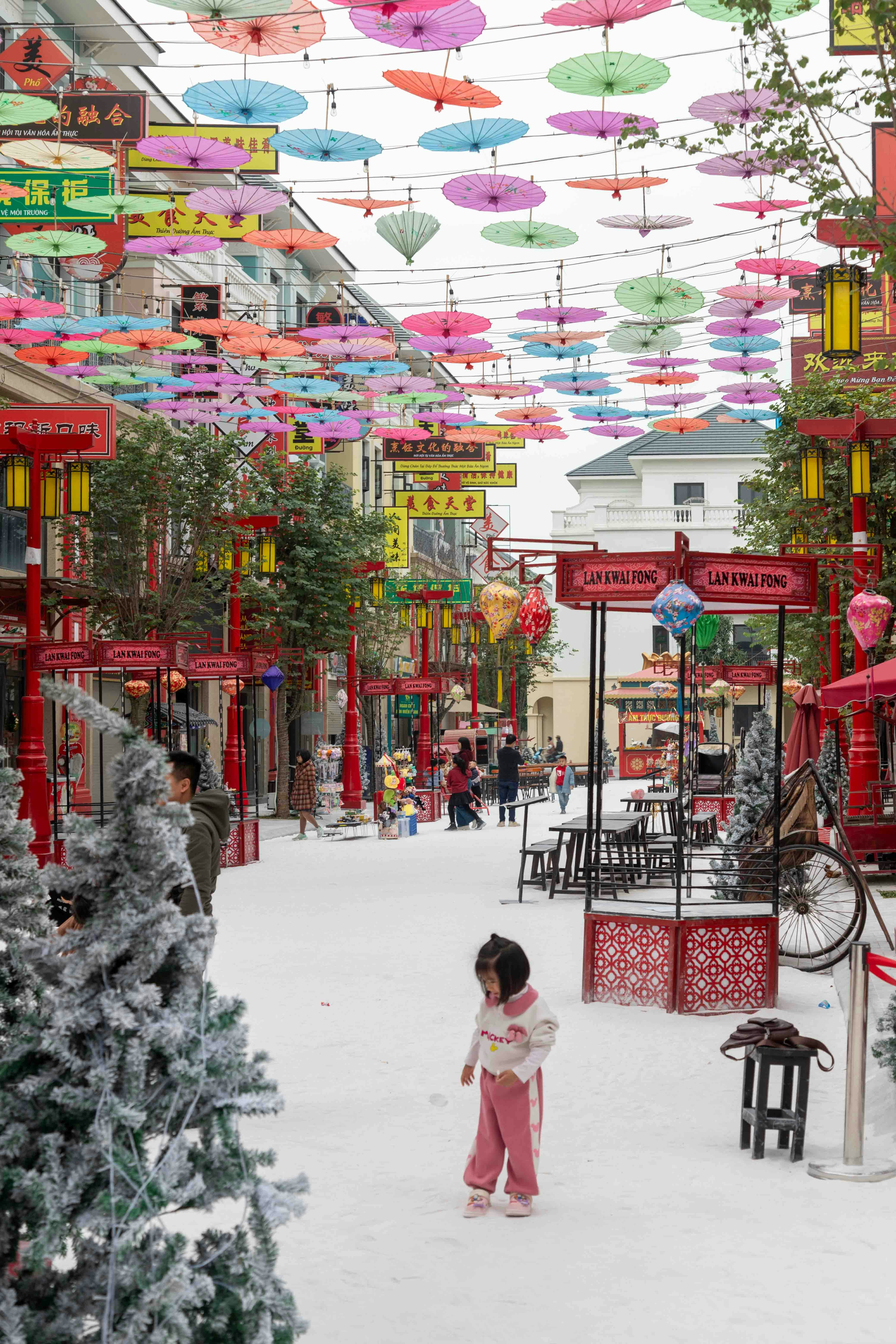 Luminous Lantern Alley: A Snowy Street Festooned with Colorful Umbrellas