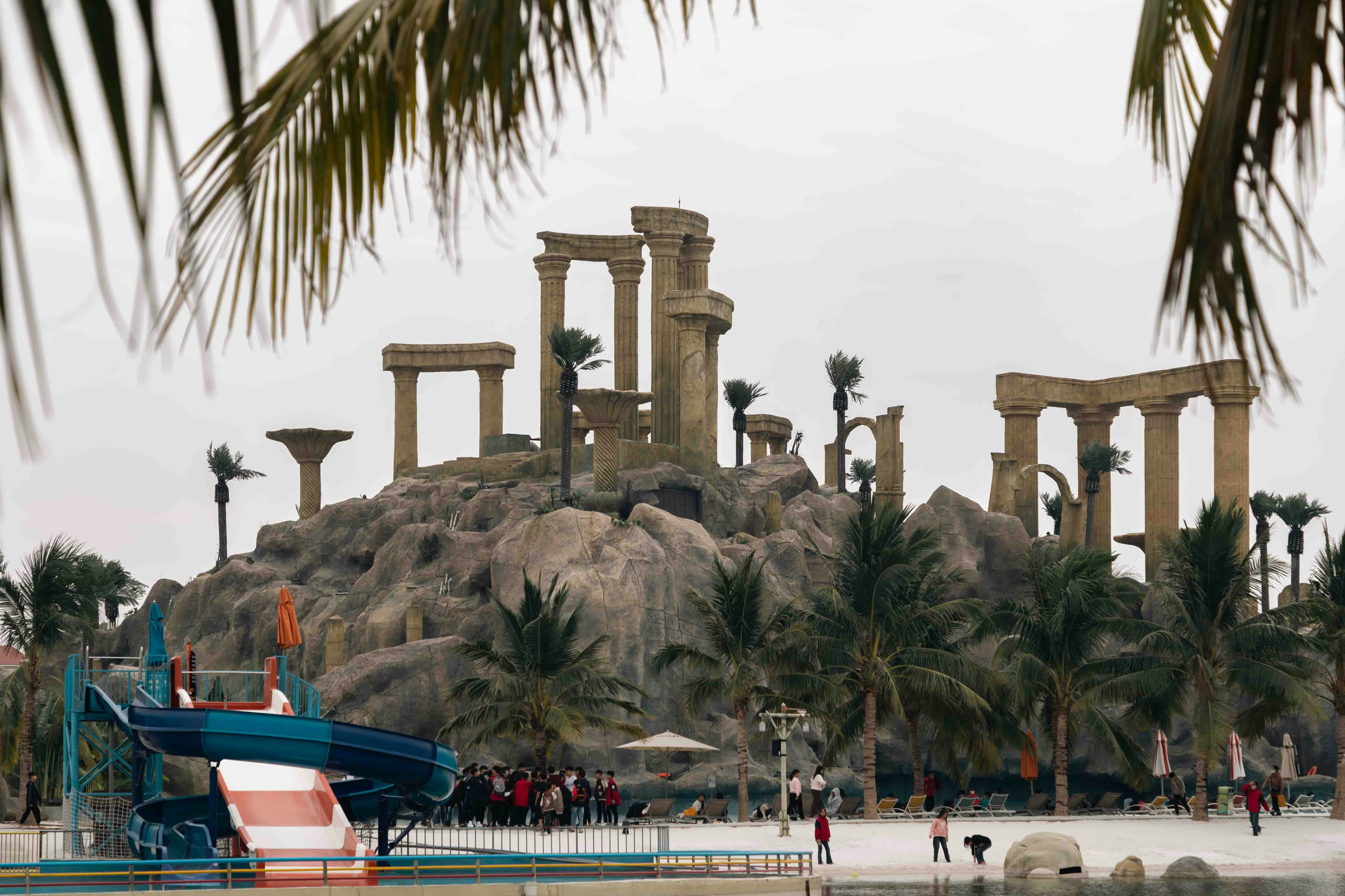 Ancient Ruins Rise Above a Palm-Fringed Beach Playground