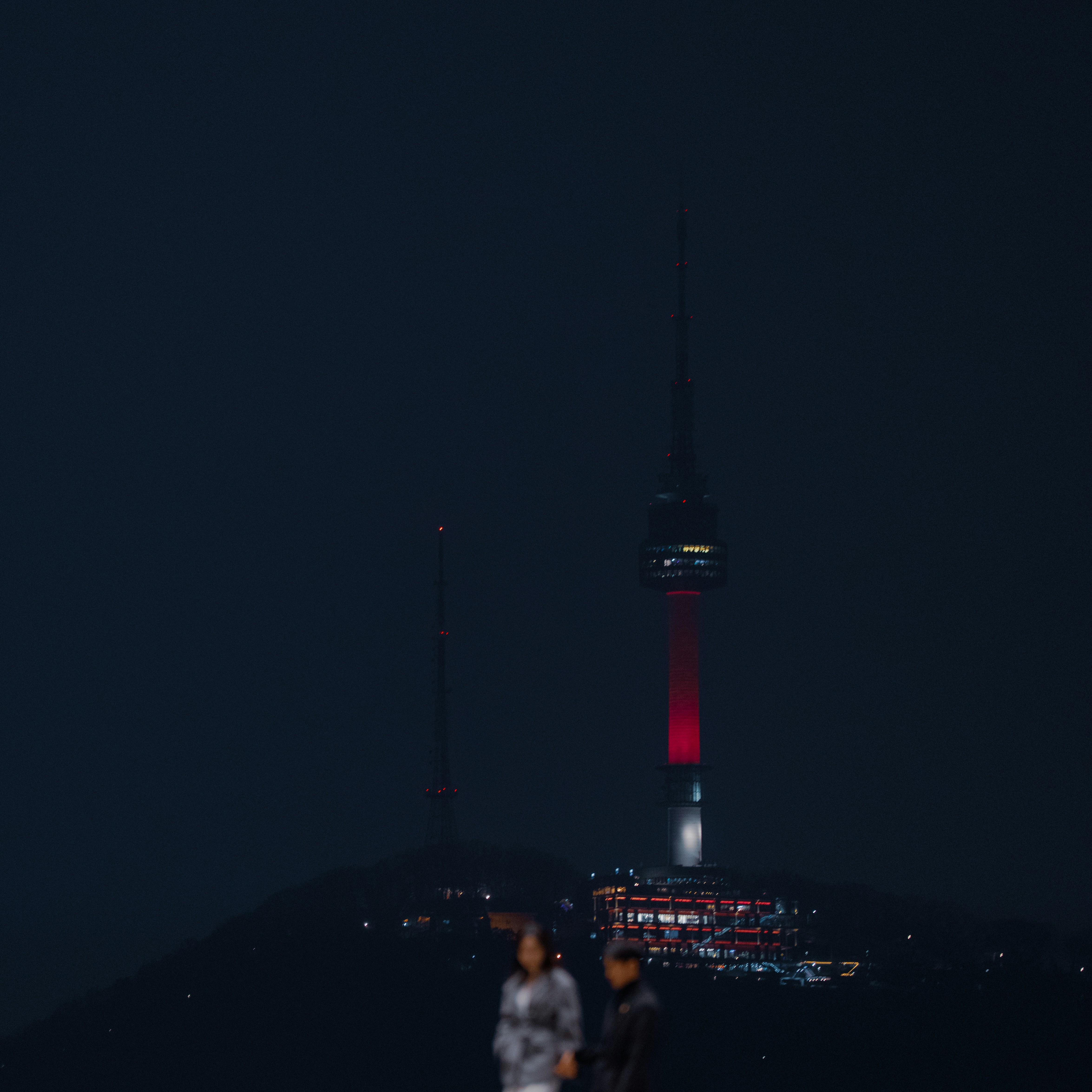 Night silhouettes at a city tower plaza
