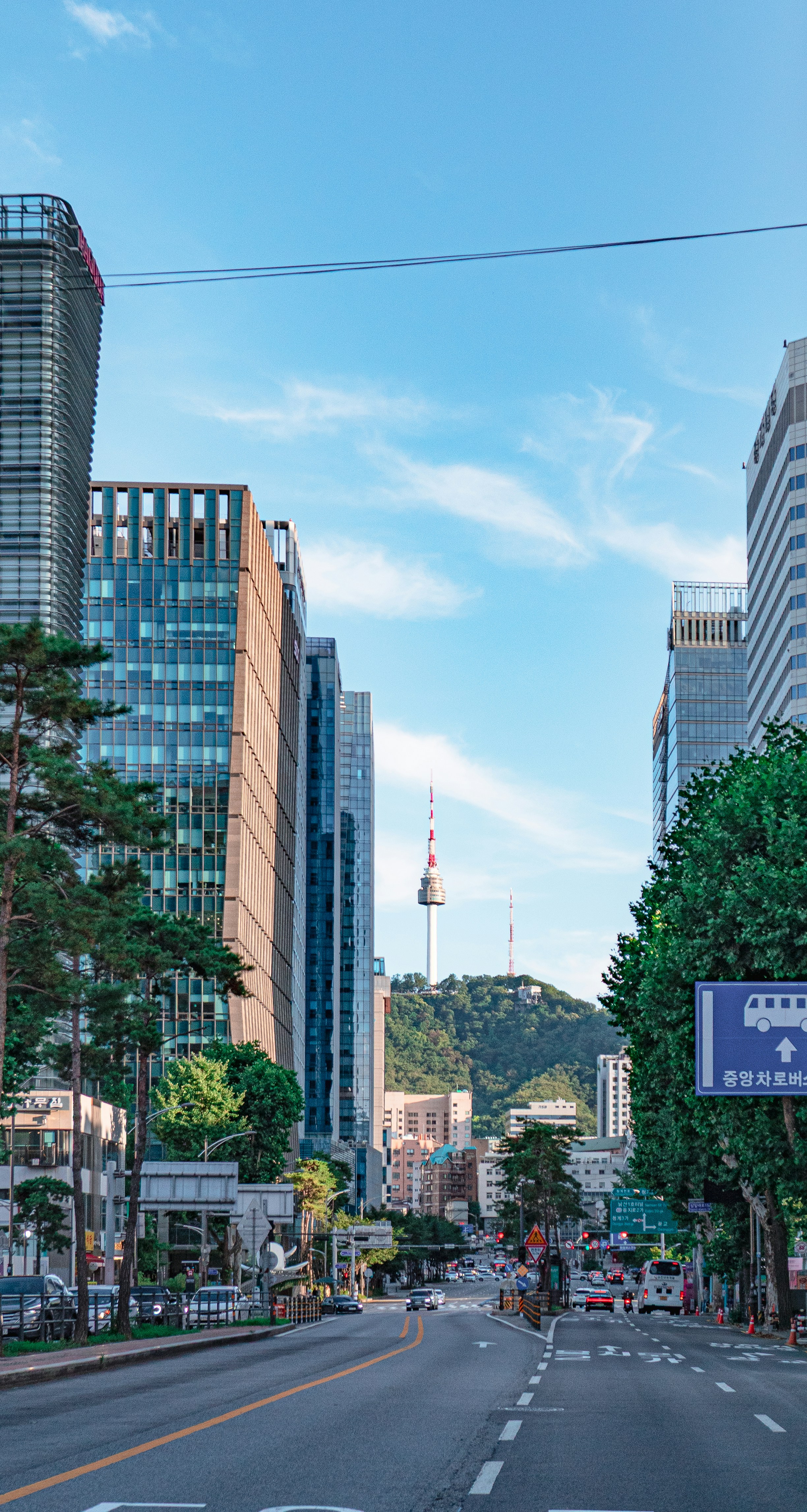 City street with tall buildings and a distant tower.