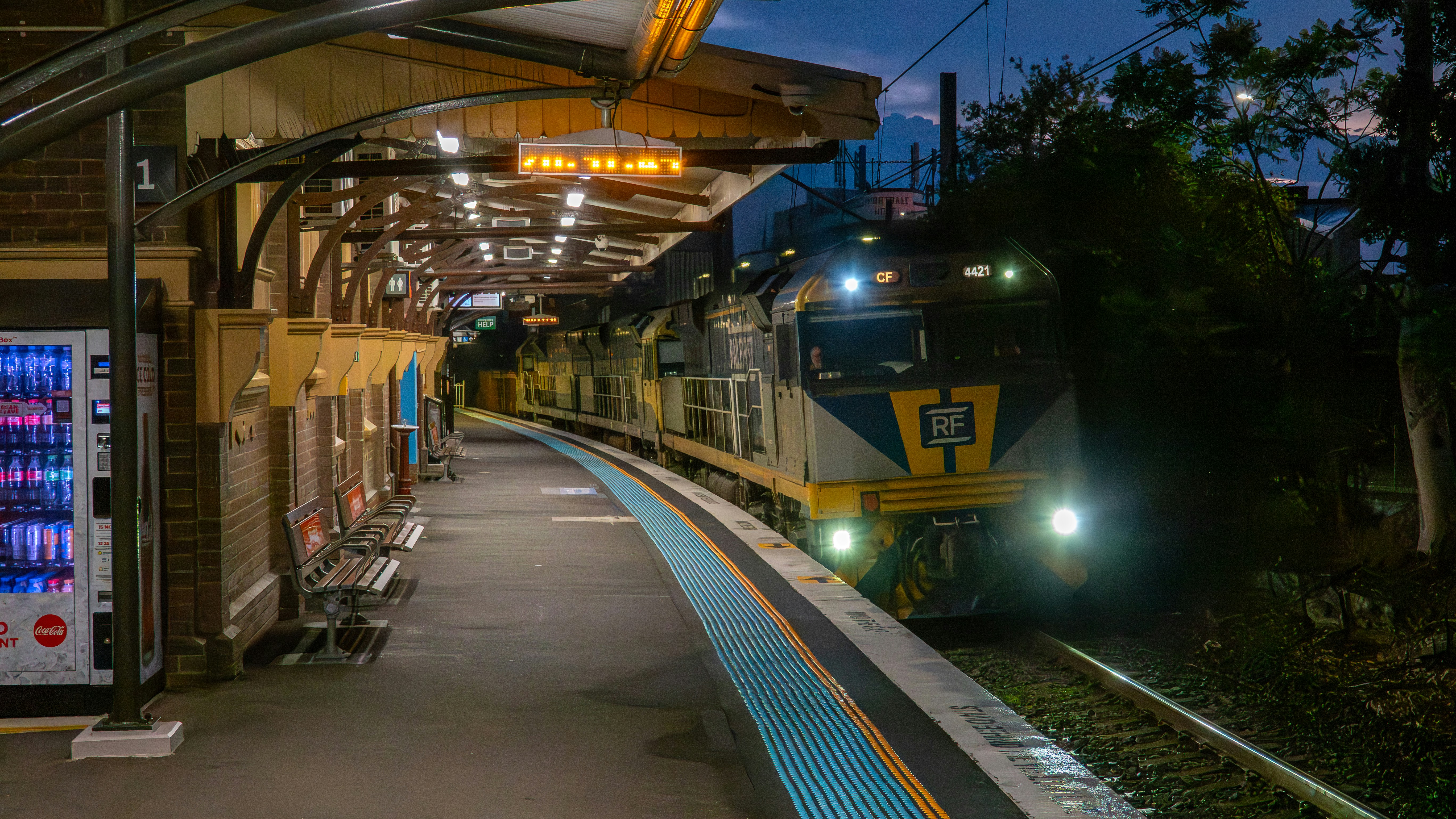 Evening Arrival: A lone freight engine glides into a quiet platform
