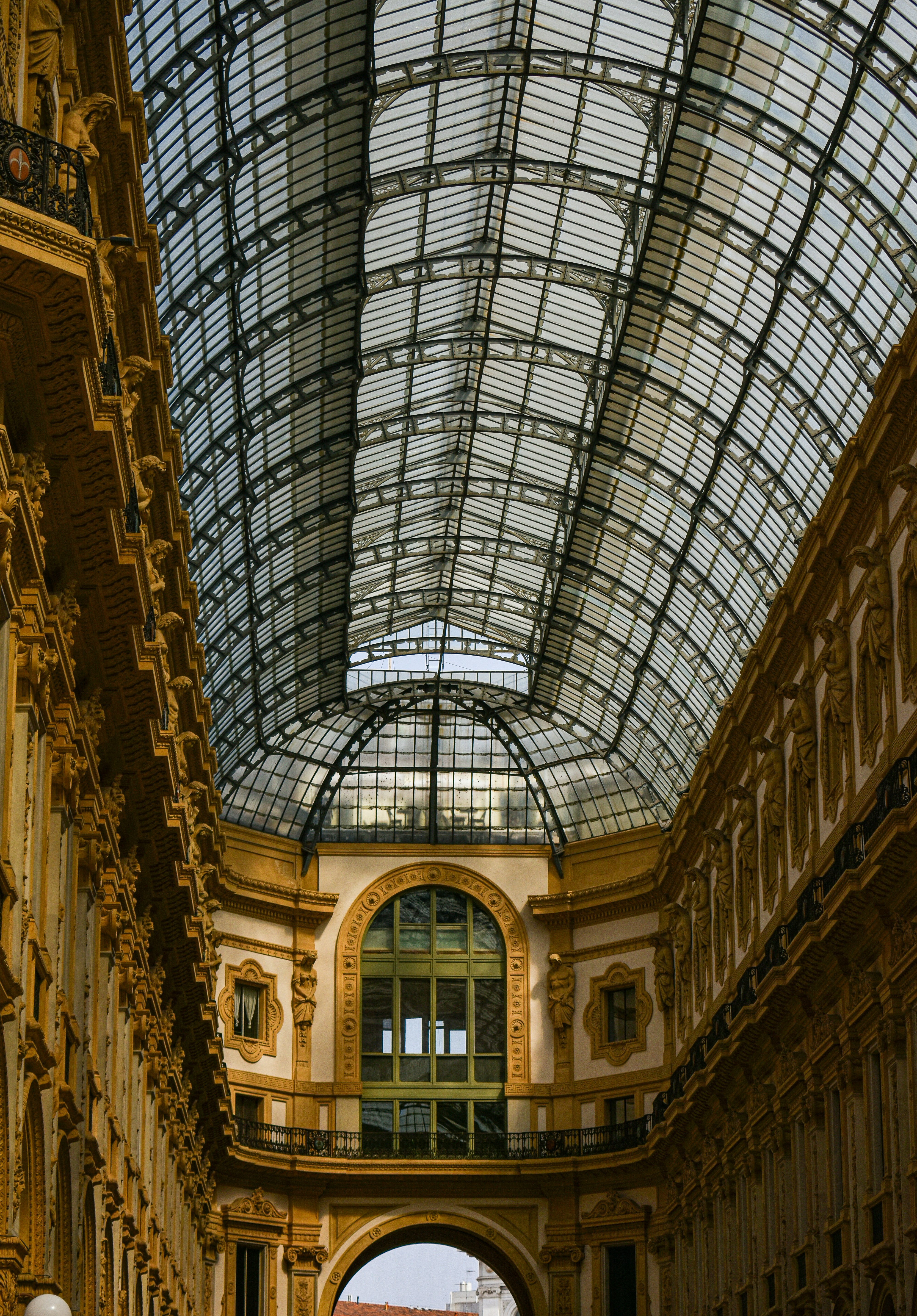 Glassvaulted Atrium: Sunlit Archway Between Ornate Facades