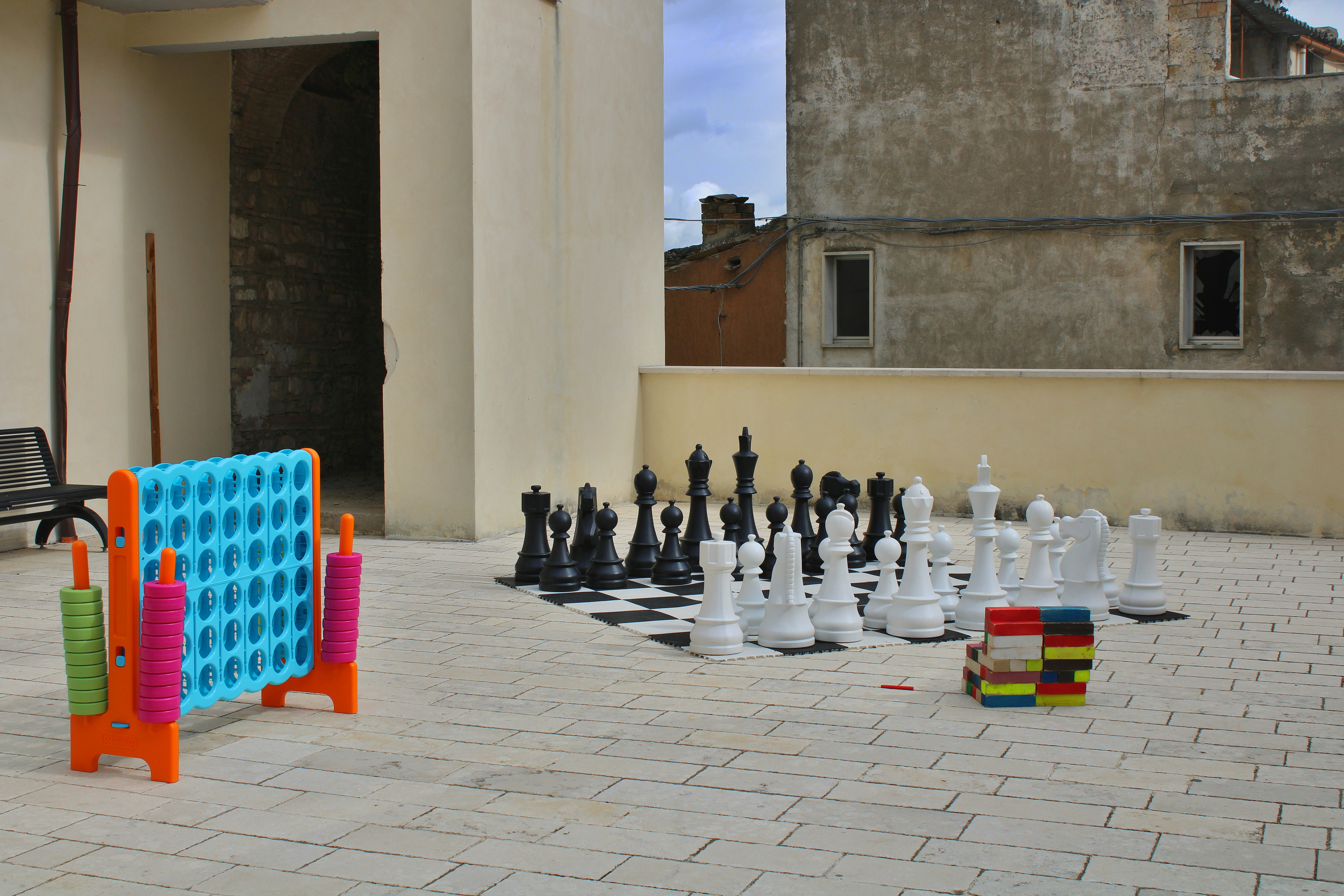 Playful Strategy: A rooftop courtyard with oversized Connect Four and a chessboard lives on a quiet afternoon