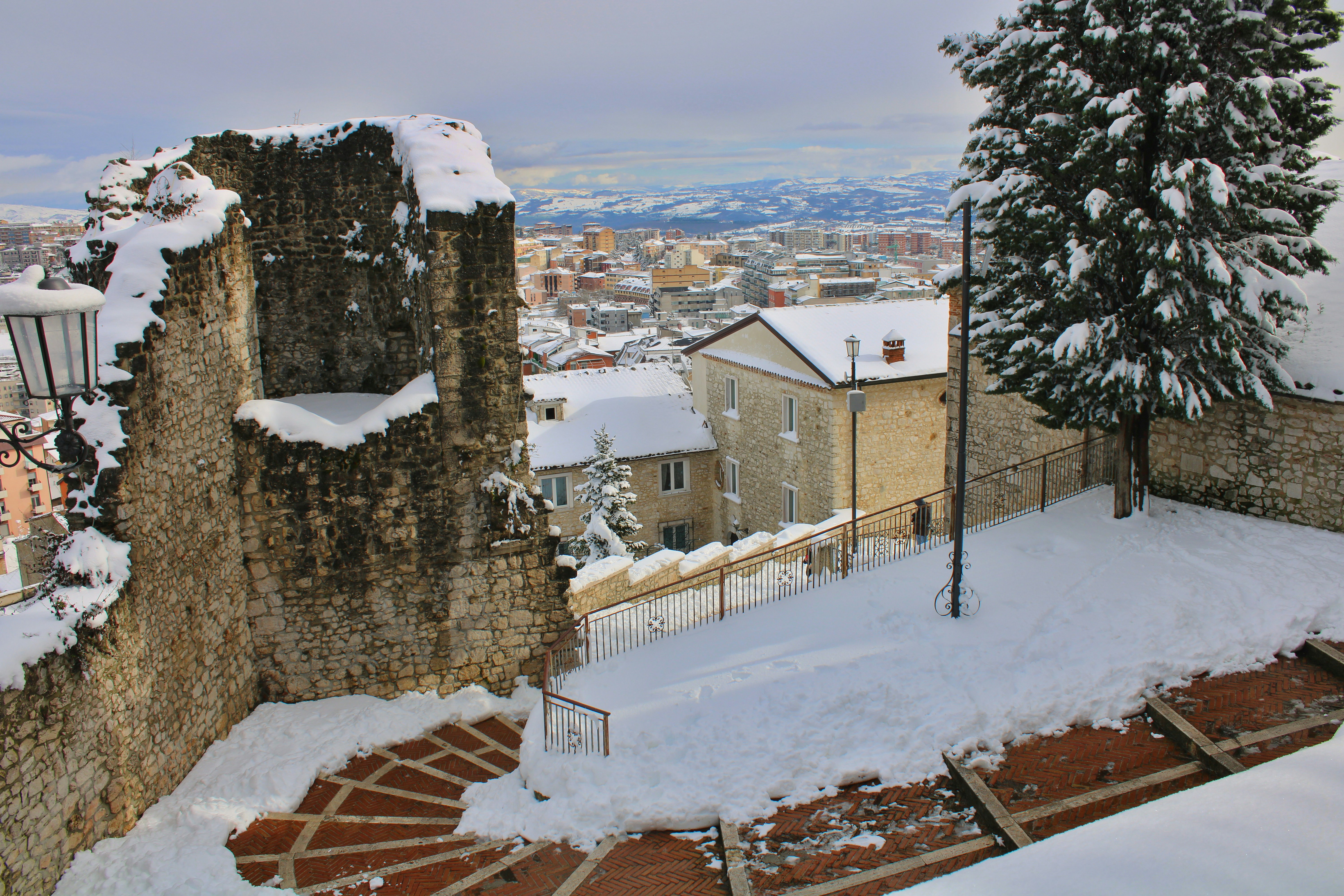 Snowbound Stones: A Quiet Rampart Overlooked by a Frosted Town