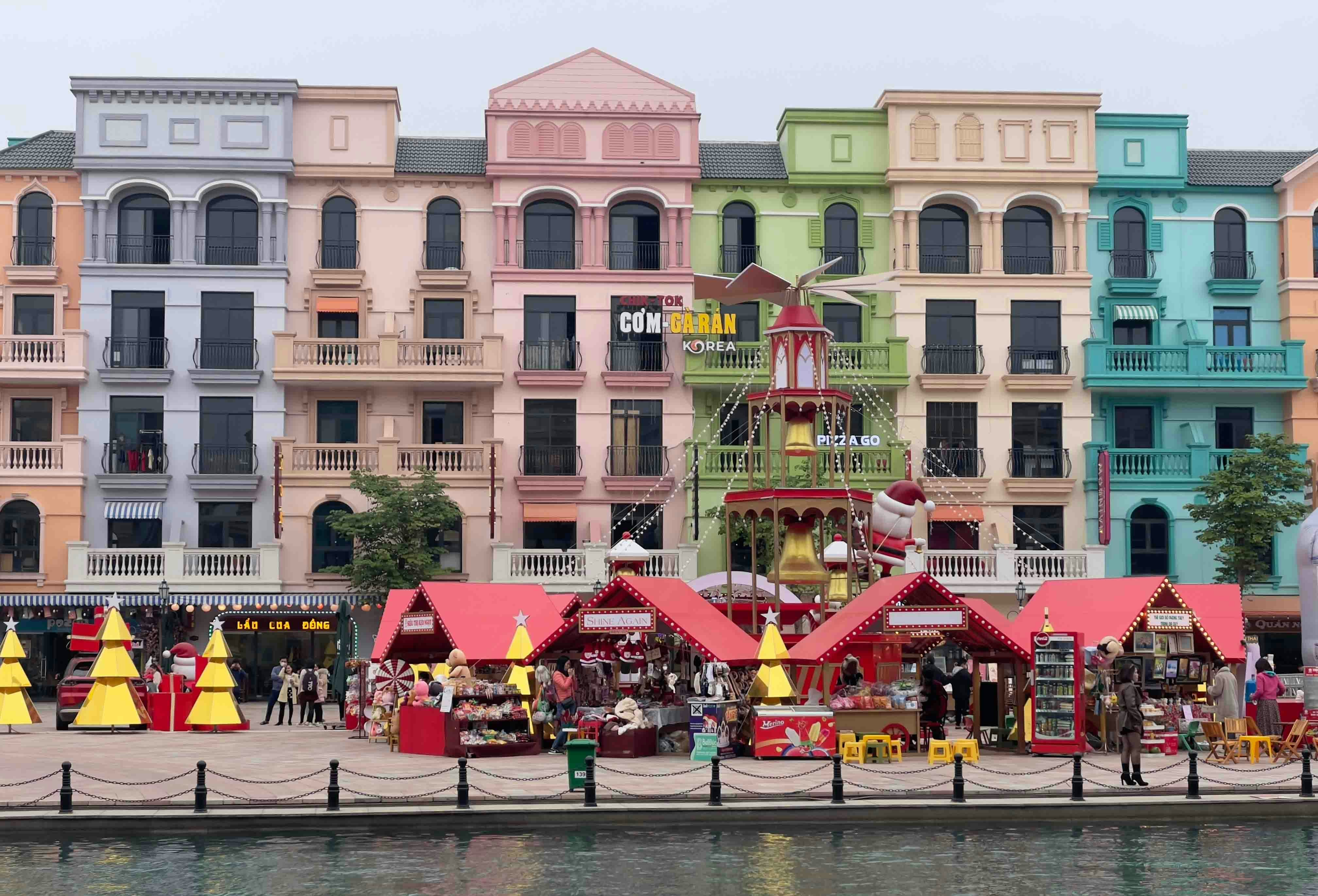 Colorful Riverside Arcade: A Row of Pastel Facades and Market Stalls