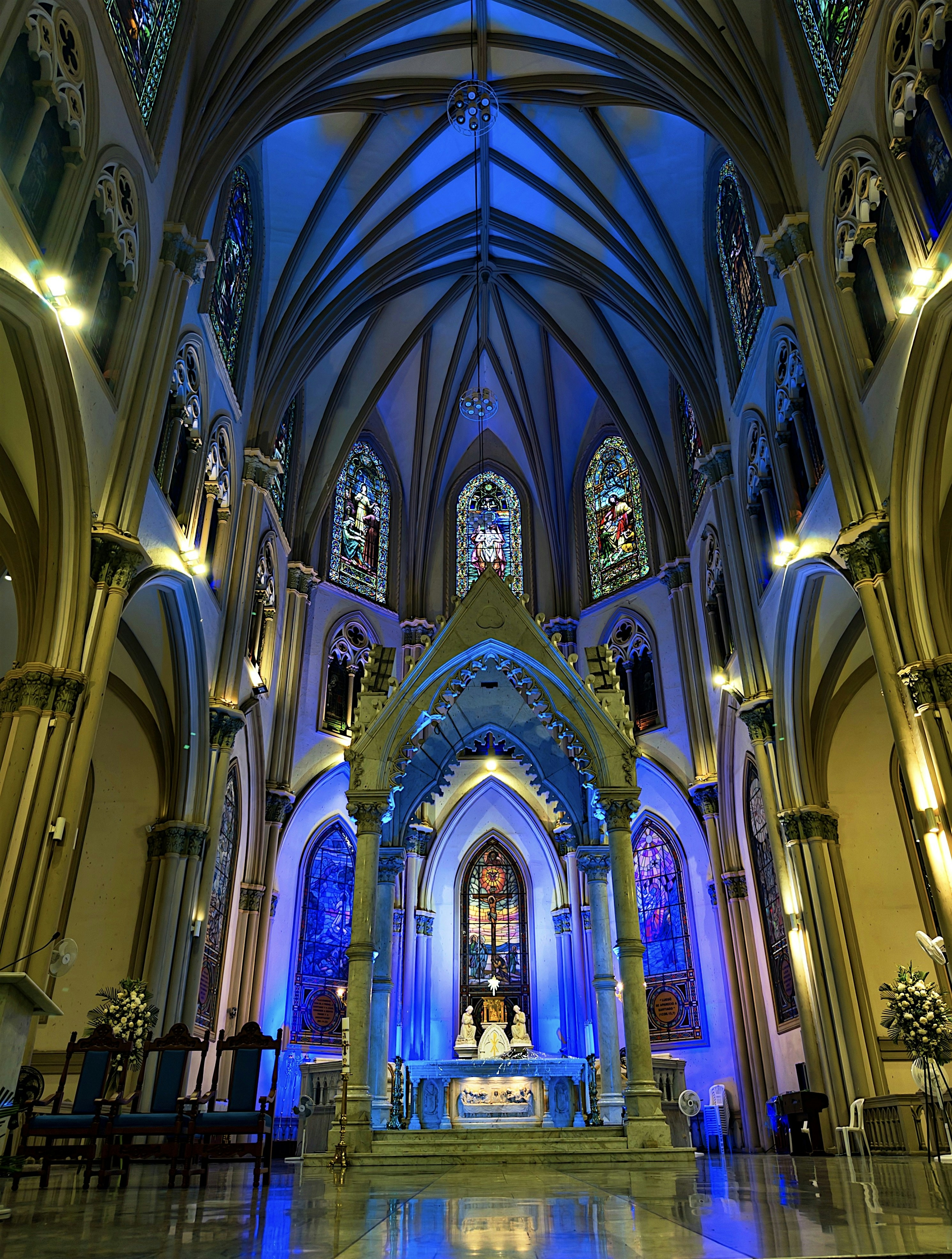 Stained light and stone: a luminous cathedral altar under vaulted blue arches