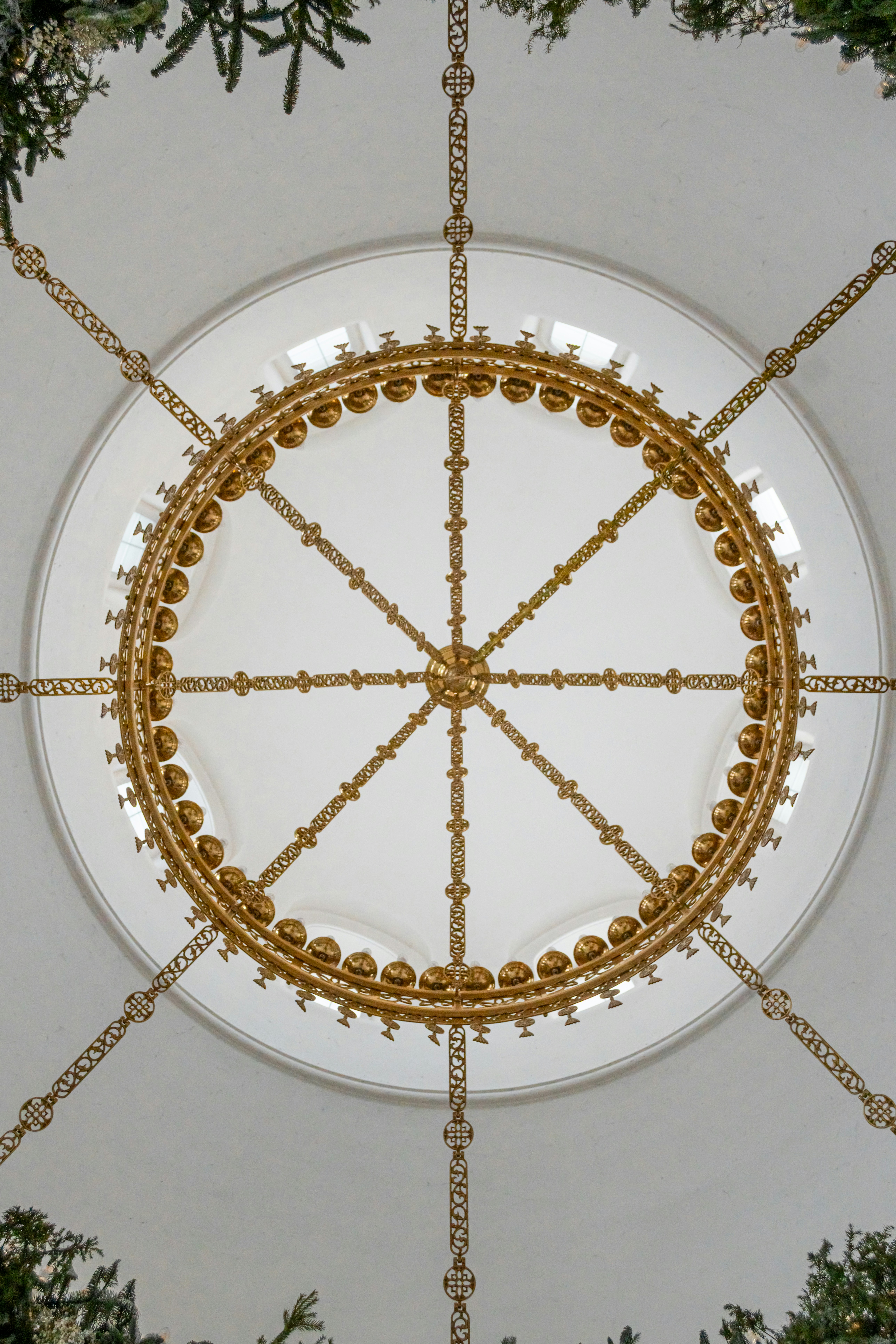 Circular Golden Mandala: An Ornate Ceiling Chandelier Framed from Below