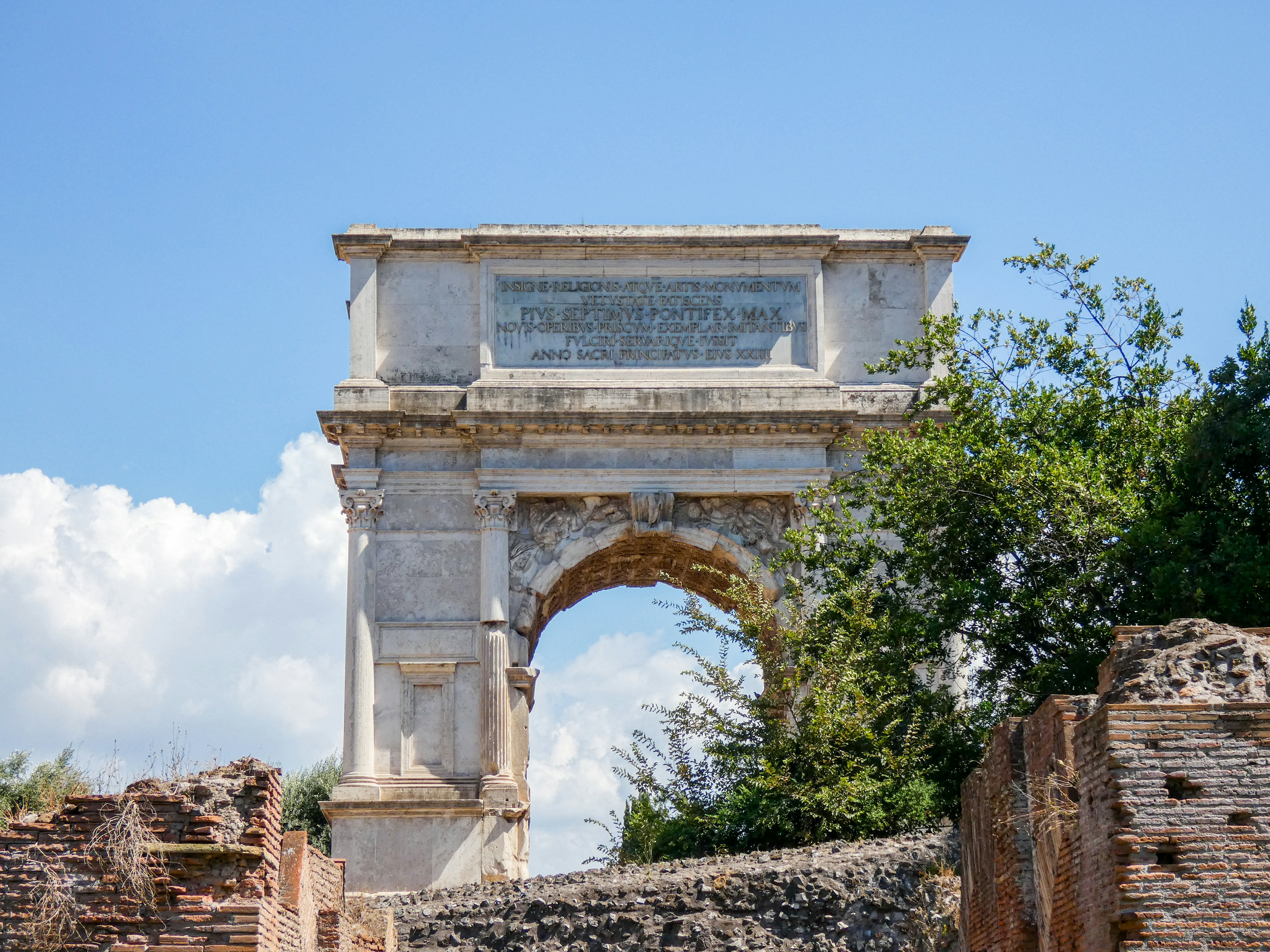 Ruins Through the Arch: A Marble Gate Framed by Encroaching Greenery