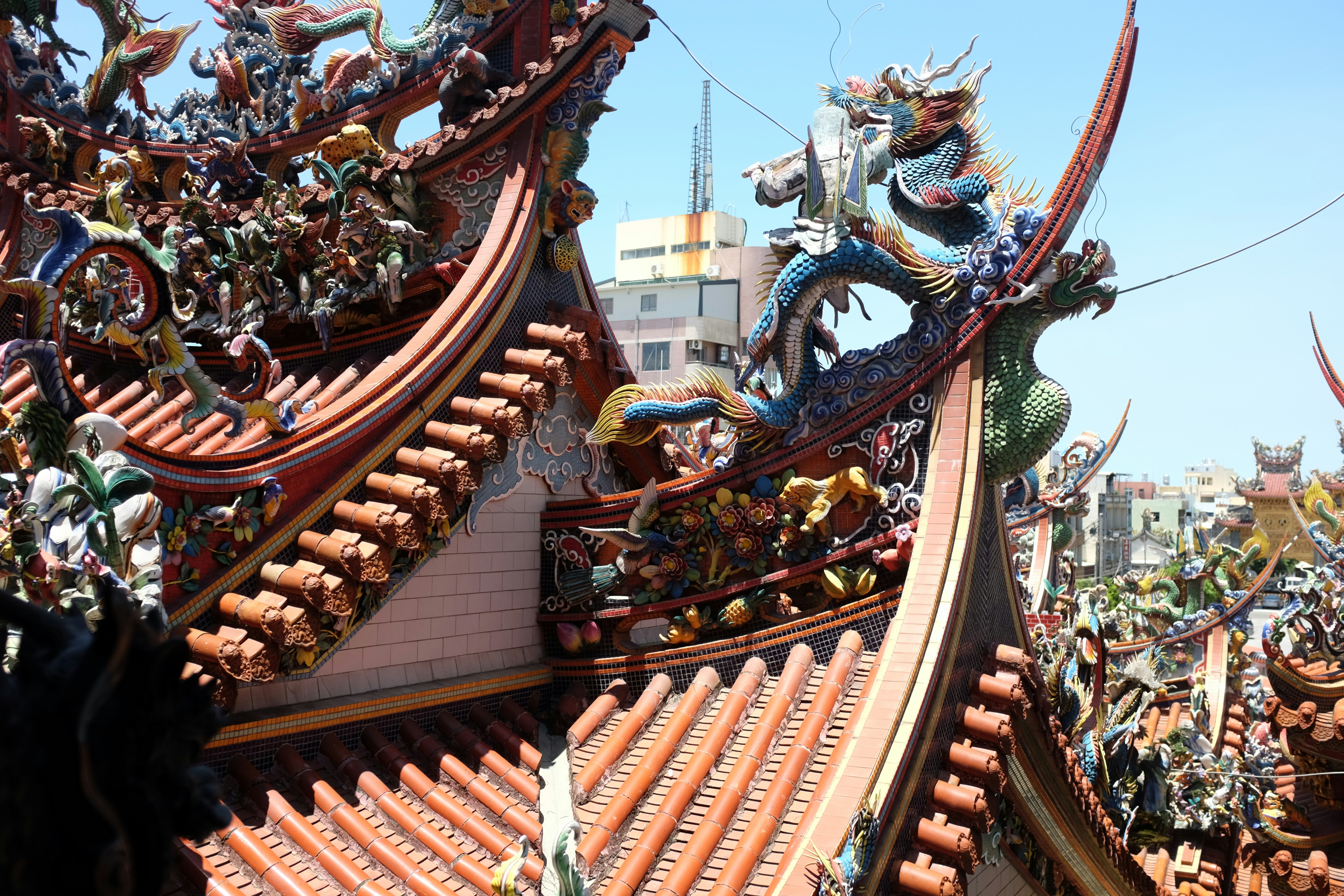 Dragon-Carved Templescape: A Burst of Rooftop Dragons against a City Skyline