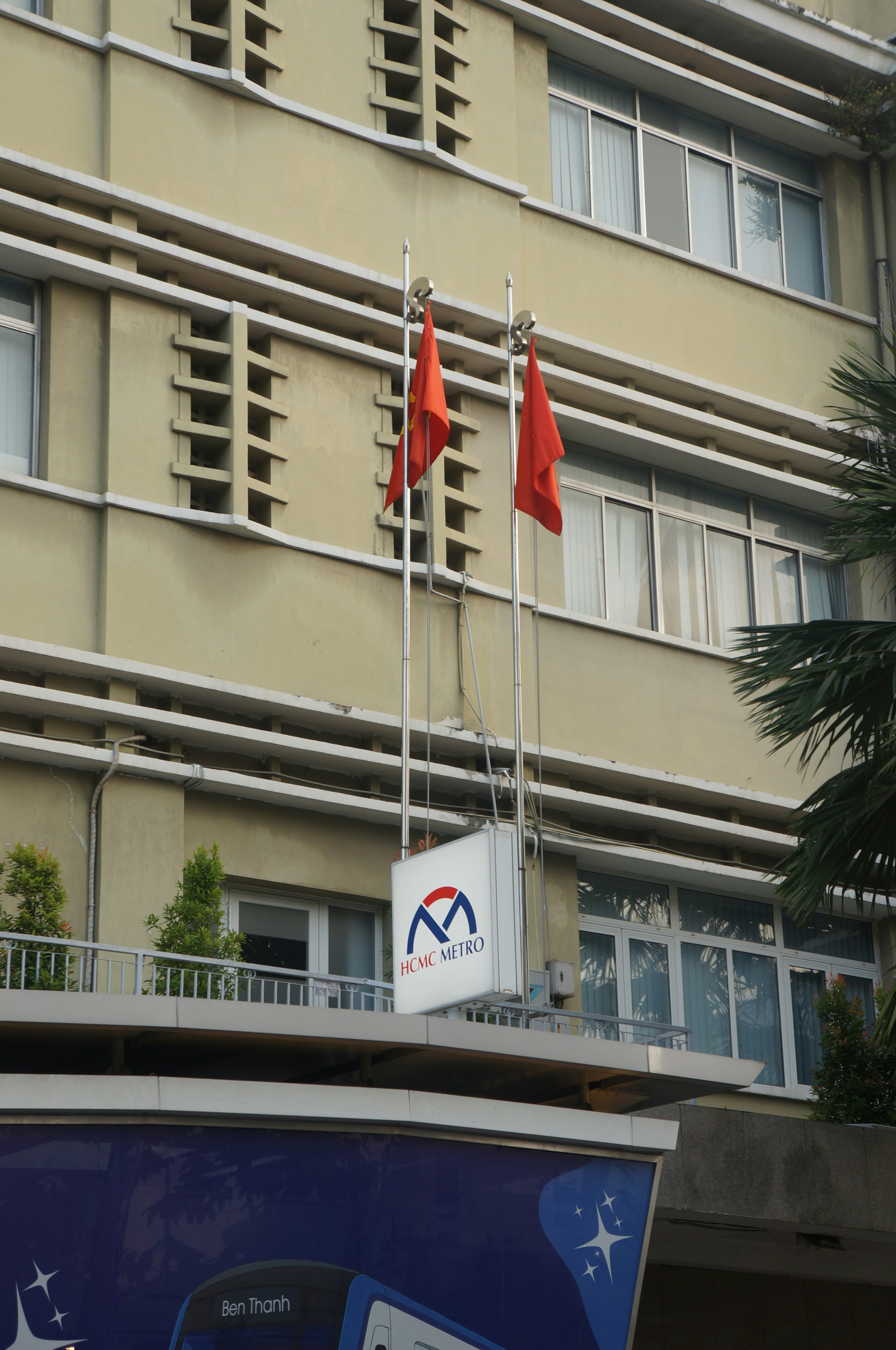 Flag poles over a municipal building with a Metro sign