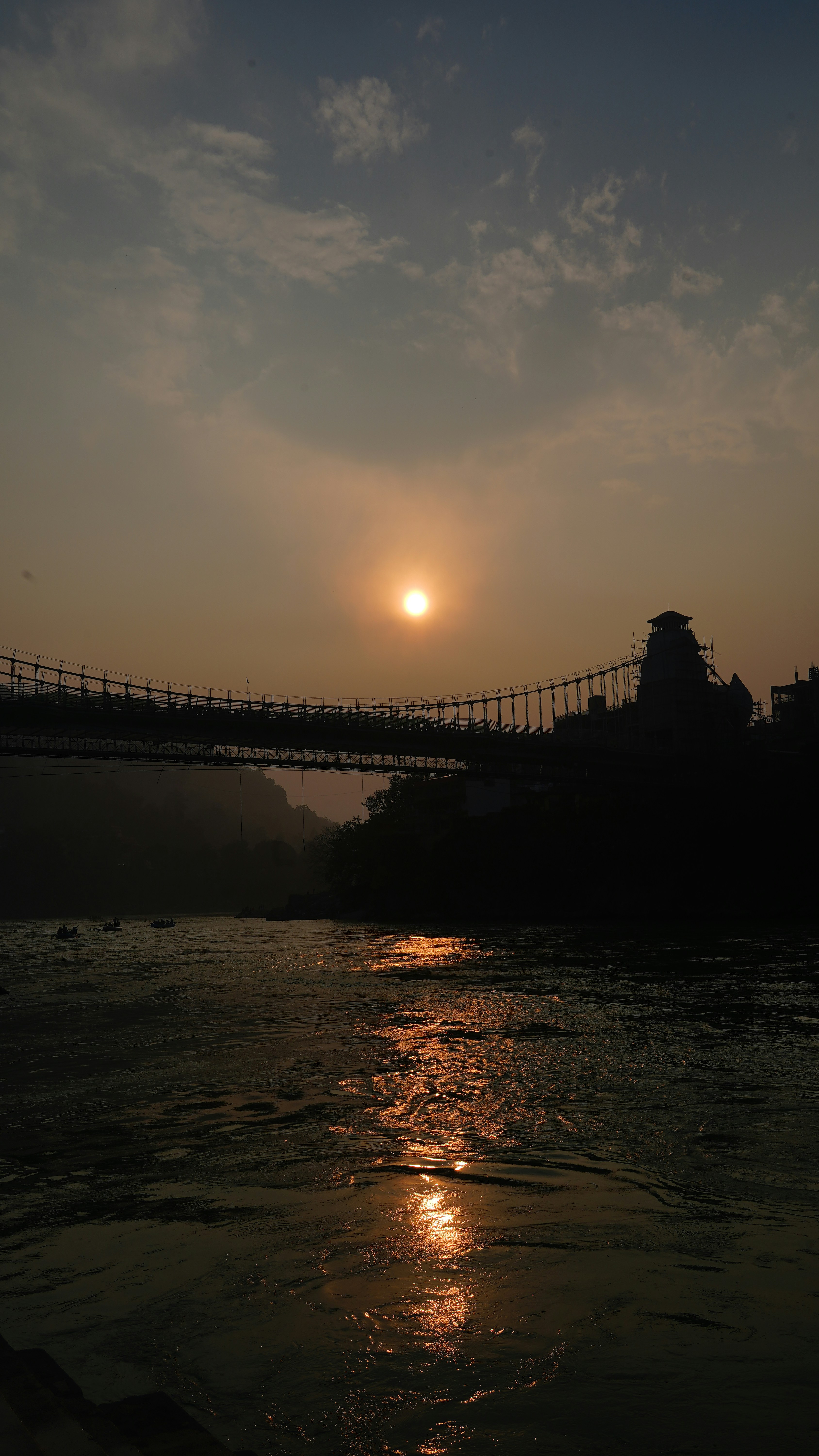 Sunlit River at Dusk Under a Suspended Bridge