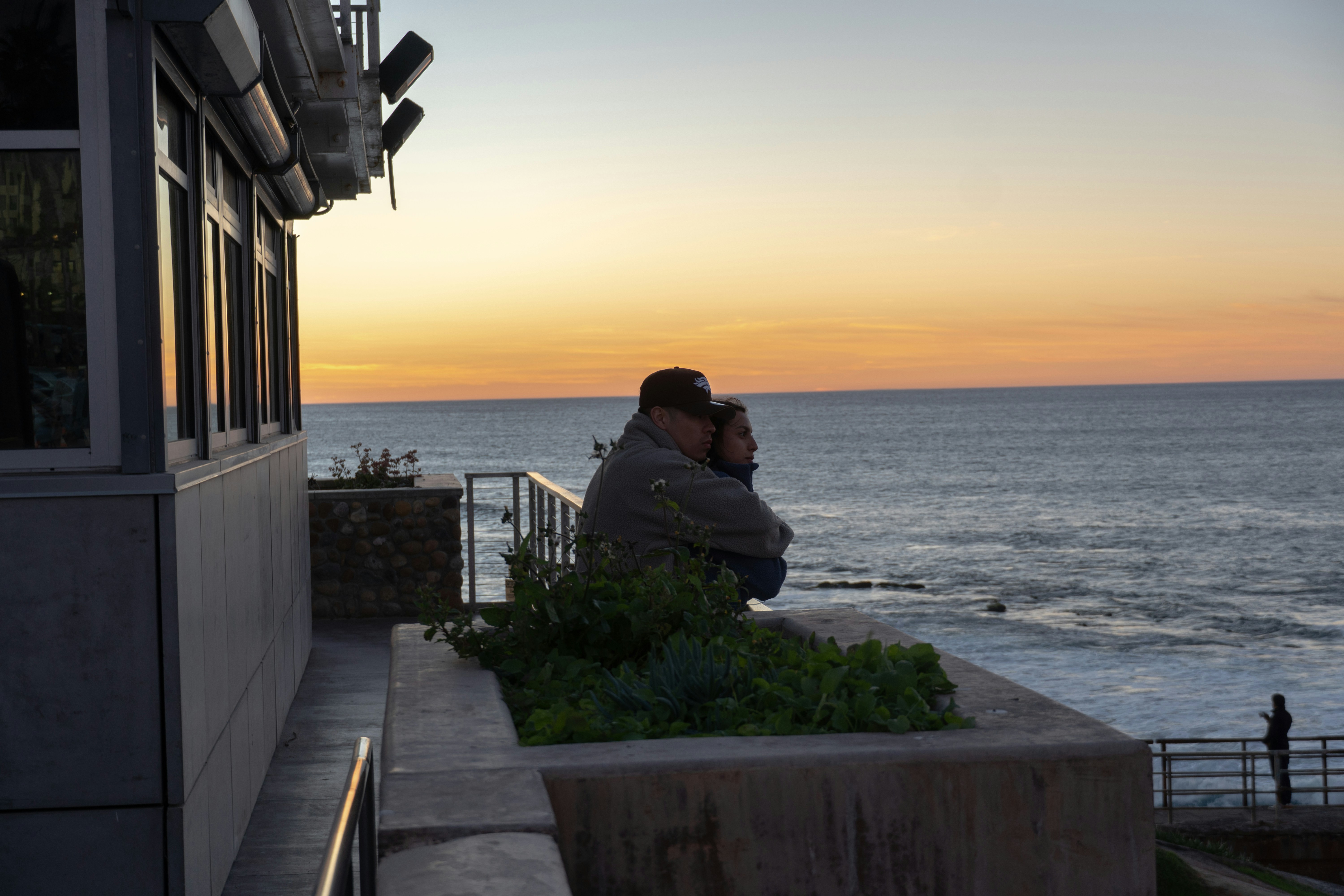 Couple on the Sea Wall Embracing at Sunset