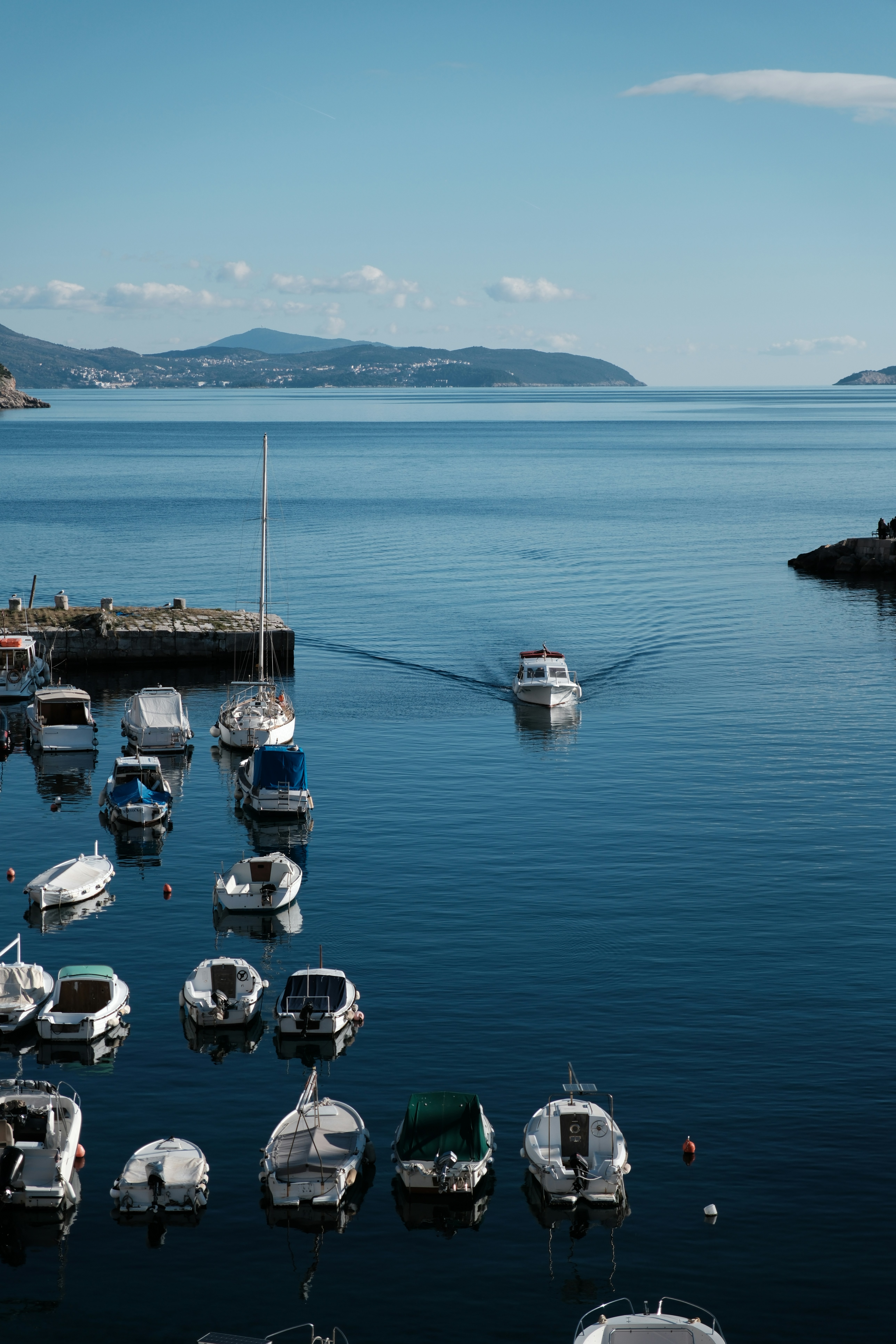 Calm Marina Afloat: Boats resting in a azure harbor under a wide coastal sky