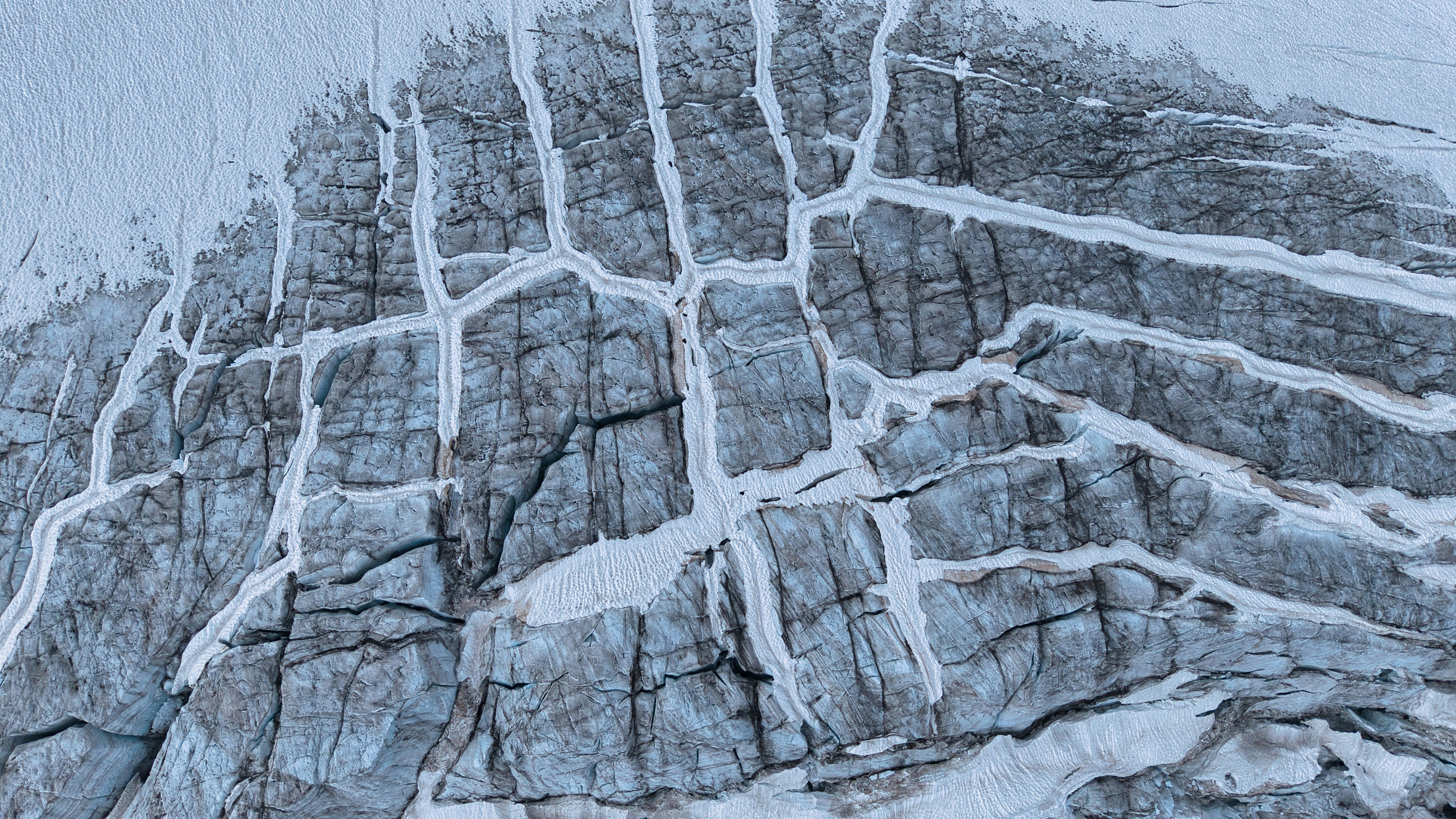 Cracked Glacier Lines: A frozen mosaic on cold blue rock