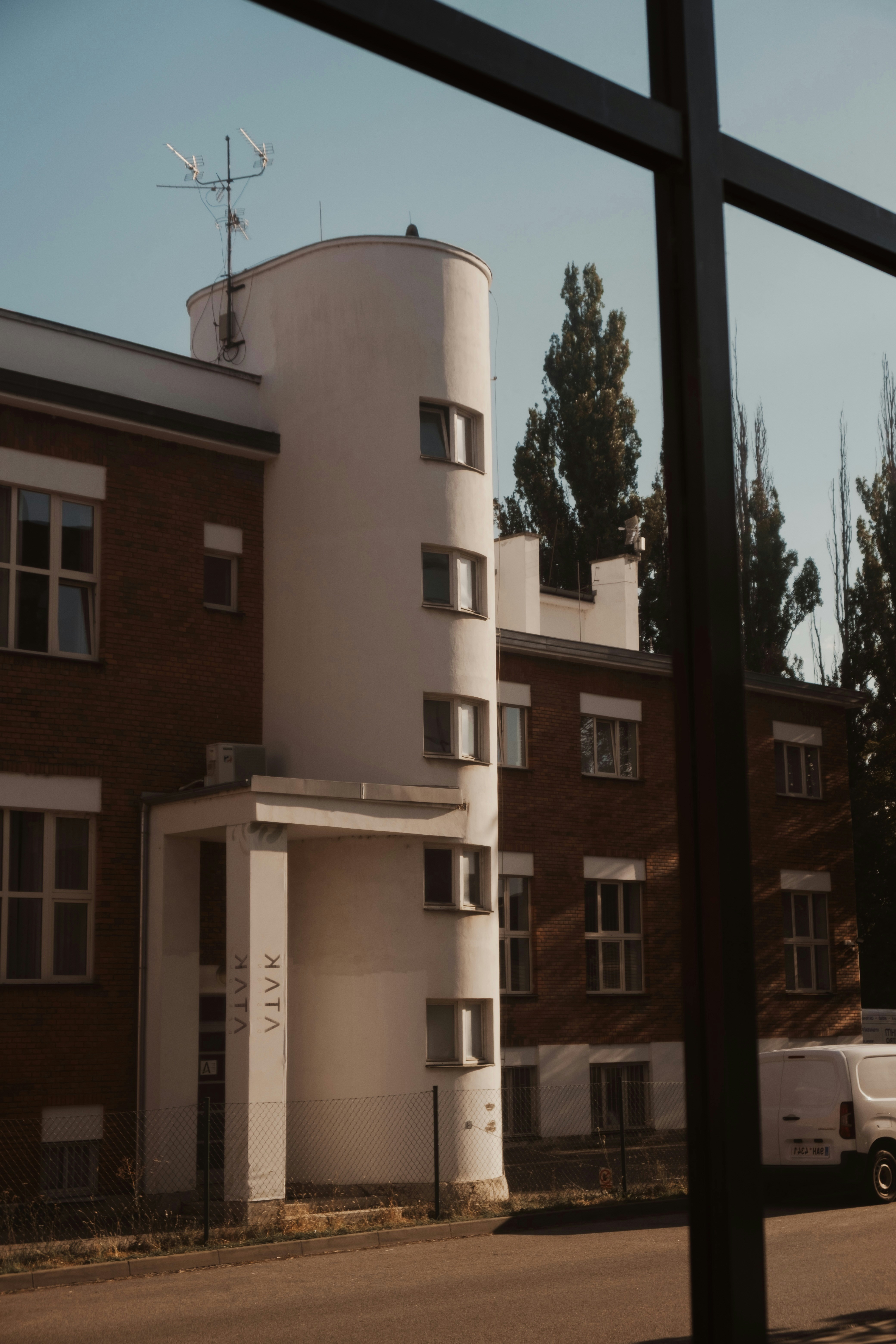 Curved Saltire: A Modernist Stairway Between Brick Facades