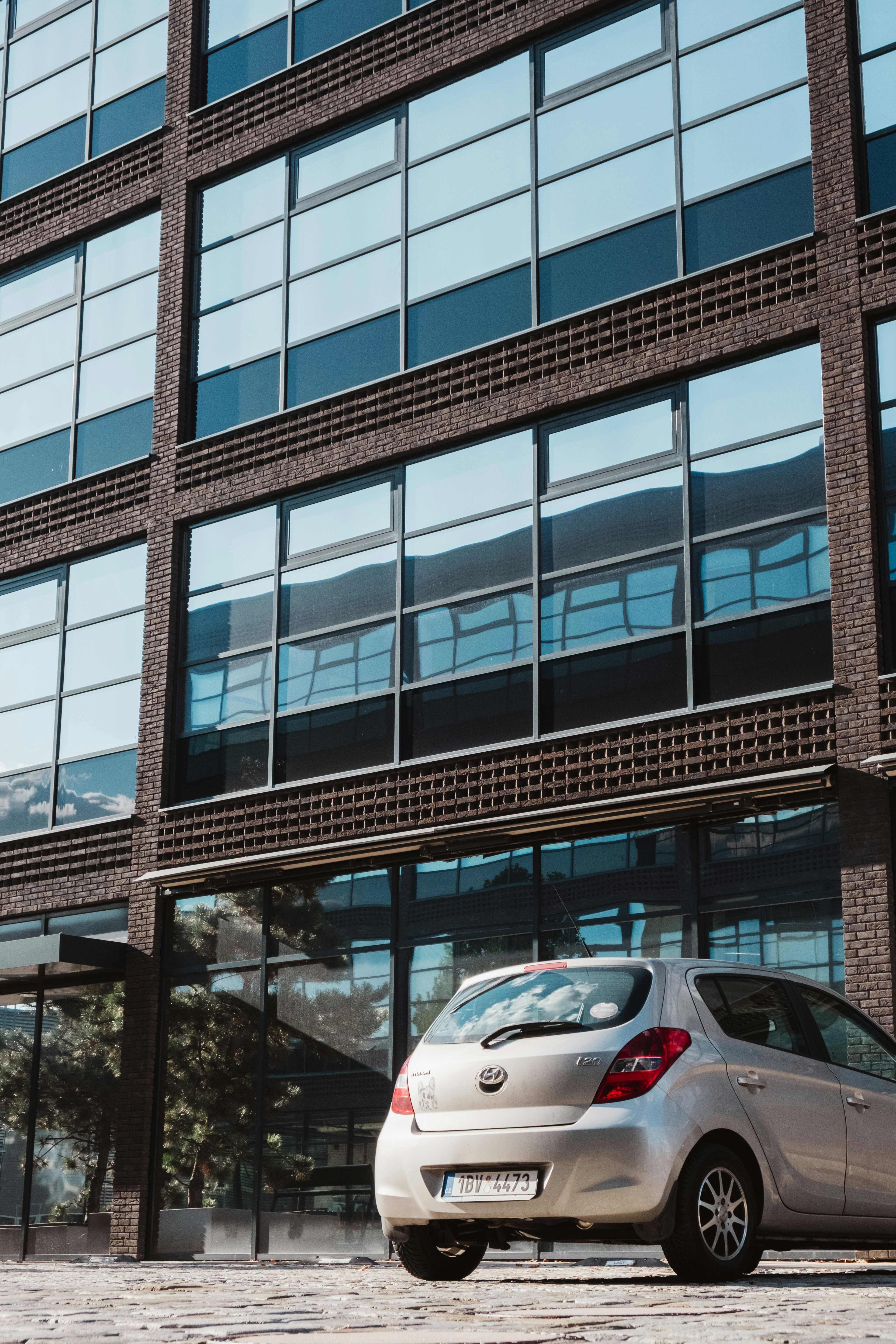 Glass-and-Brick Echo: A City Office with a Quiet Hatchback