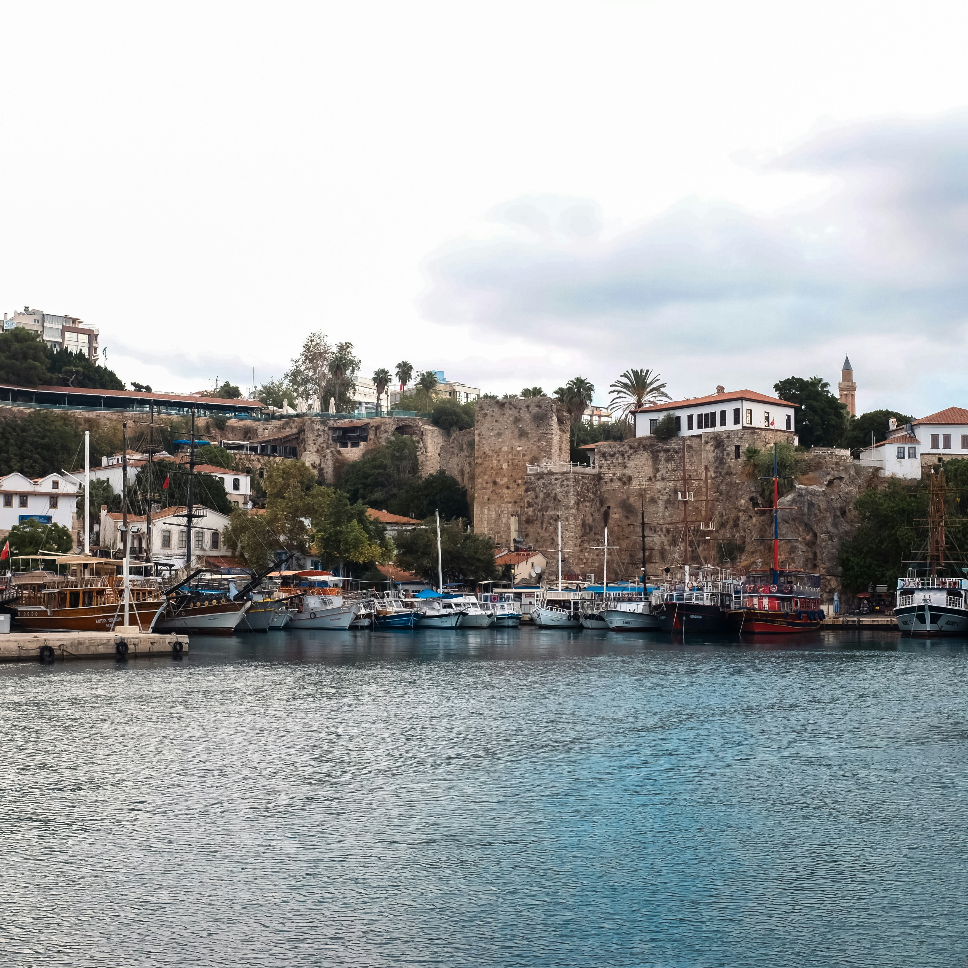 Harborfront in Sunlit Stone: Boats, Water, and Historic Walls