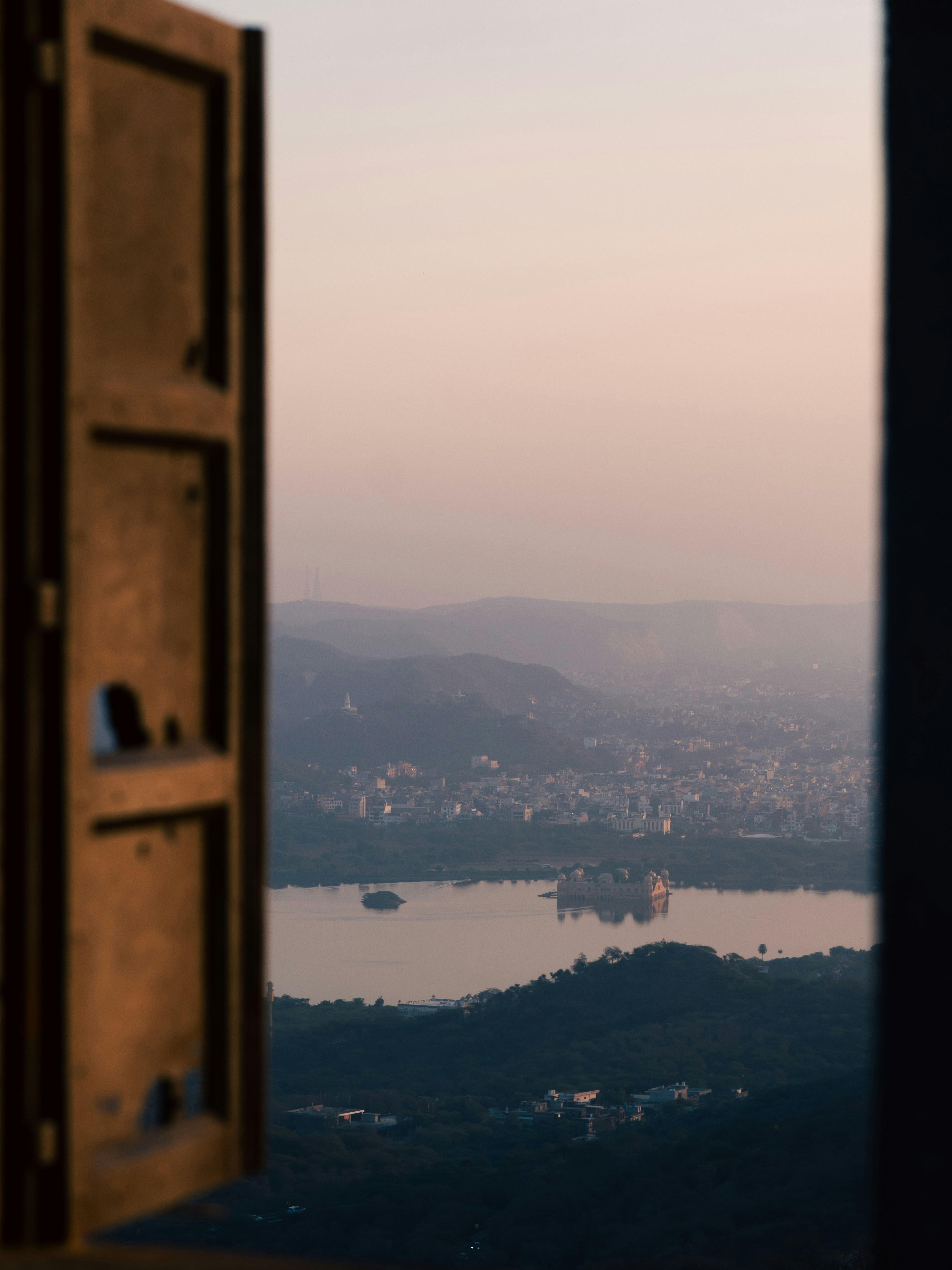 Window to the Valley: Distant City and Water between Sunset Shutters