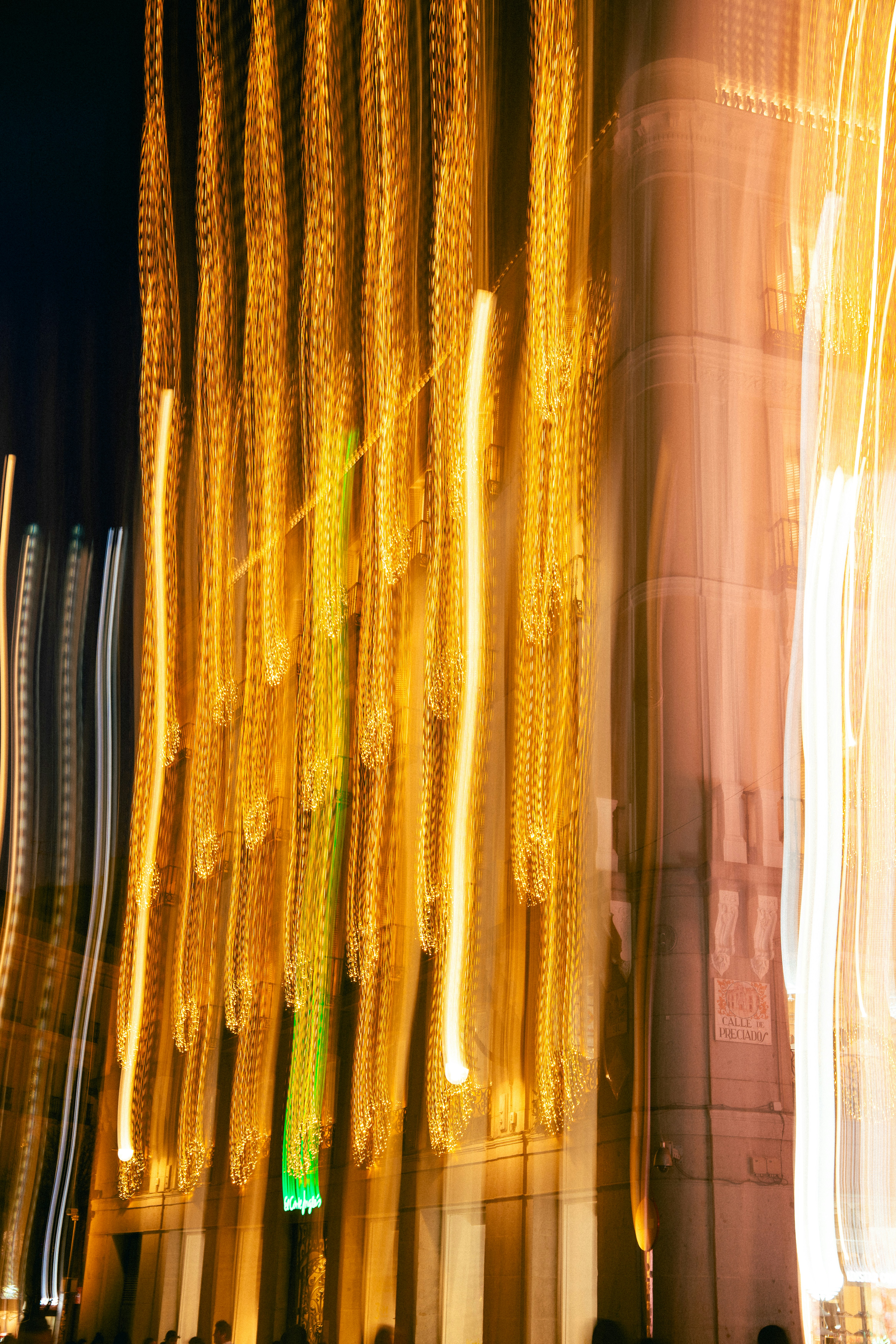 Strings of Night: Golden Trails Against Stone Architecture