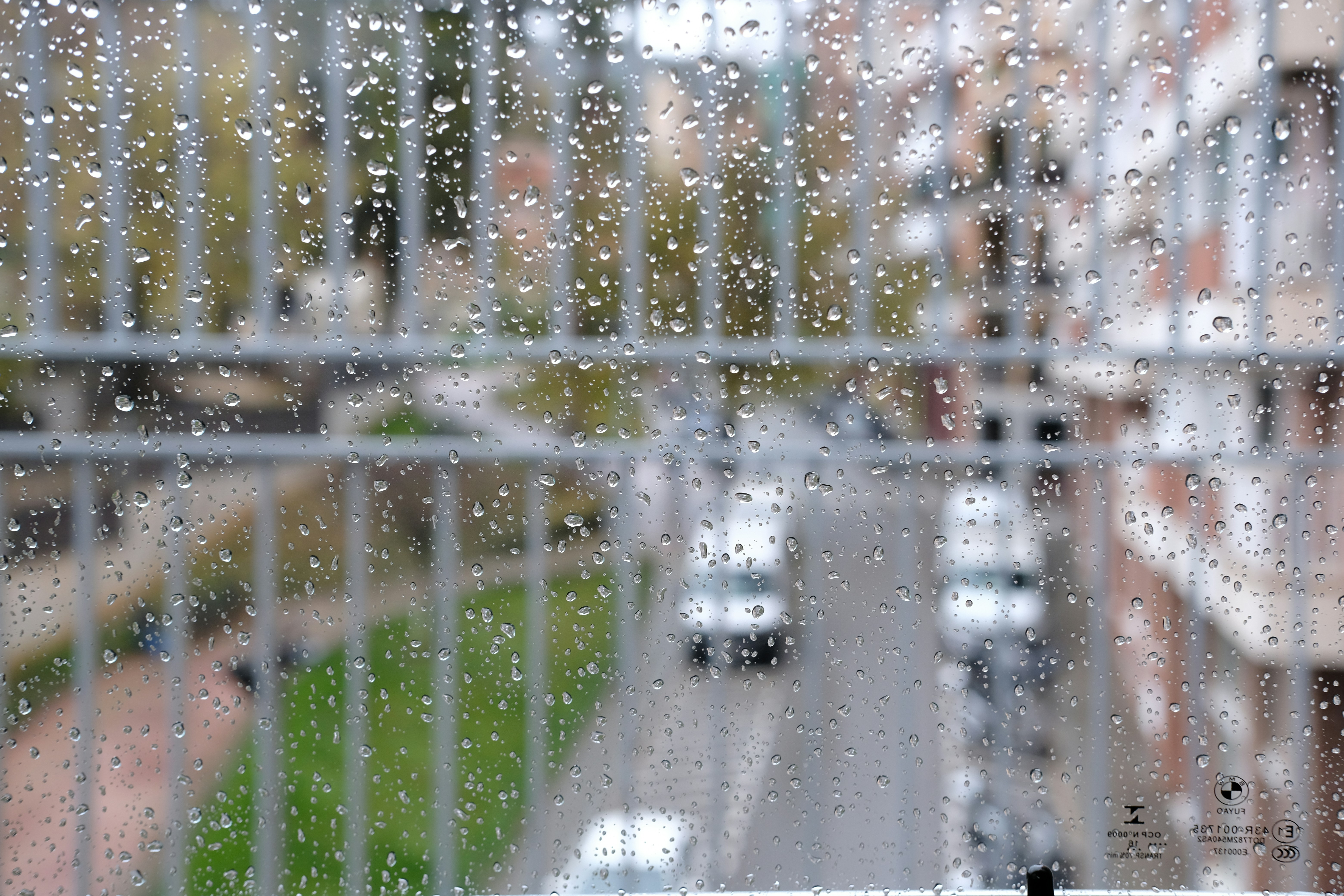 Rain-streaked barrier over a moving city street