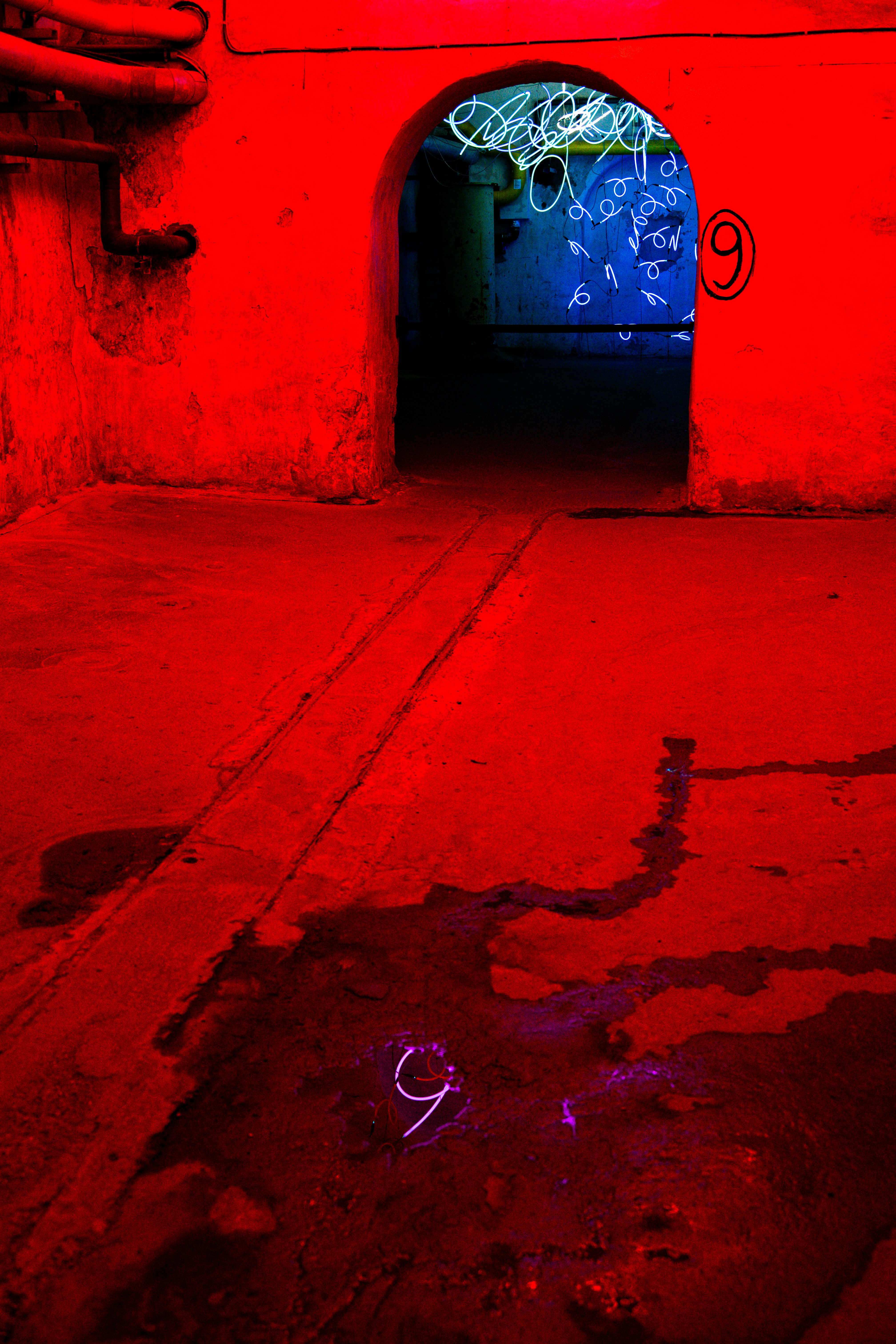 Crimson Passage: Neon Graffiti Illuminates a Red Corridor