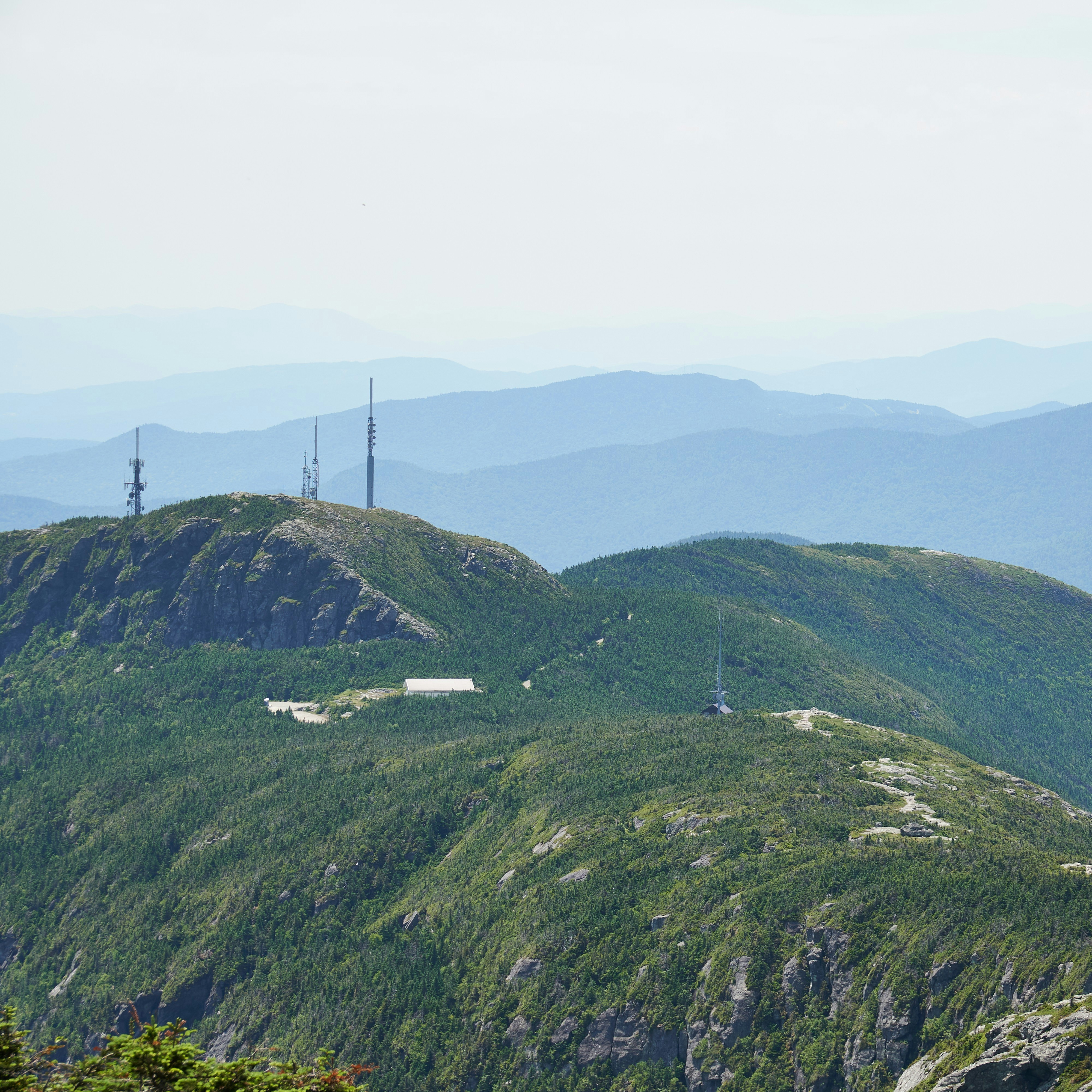 Ridgeline Watch: Antennas Silhouetted Against a Layered Mountain Horizon