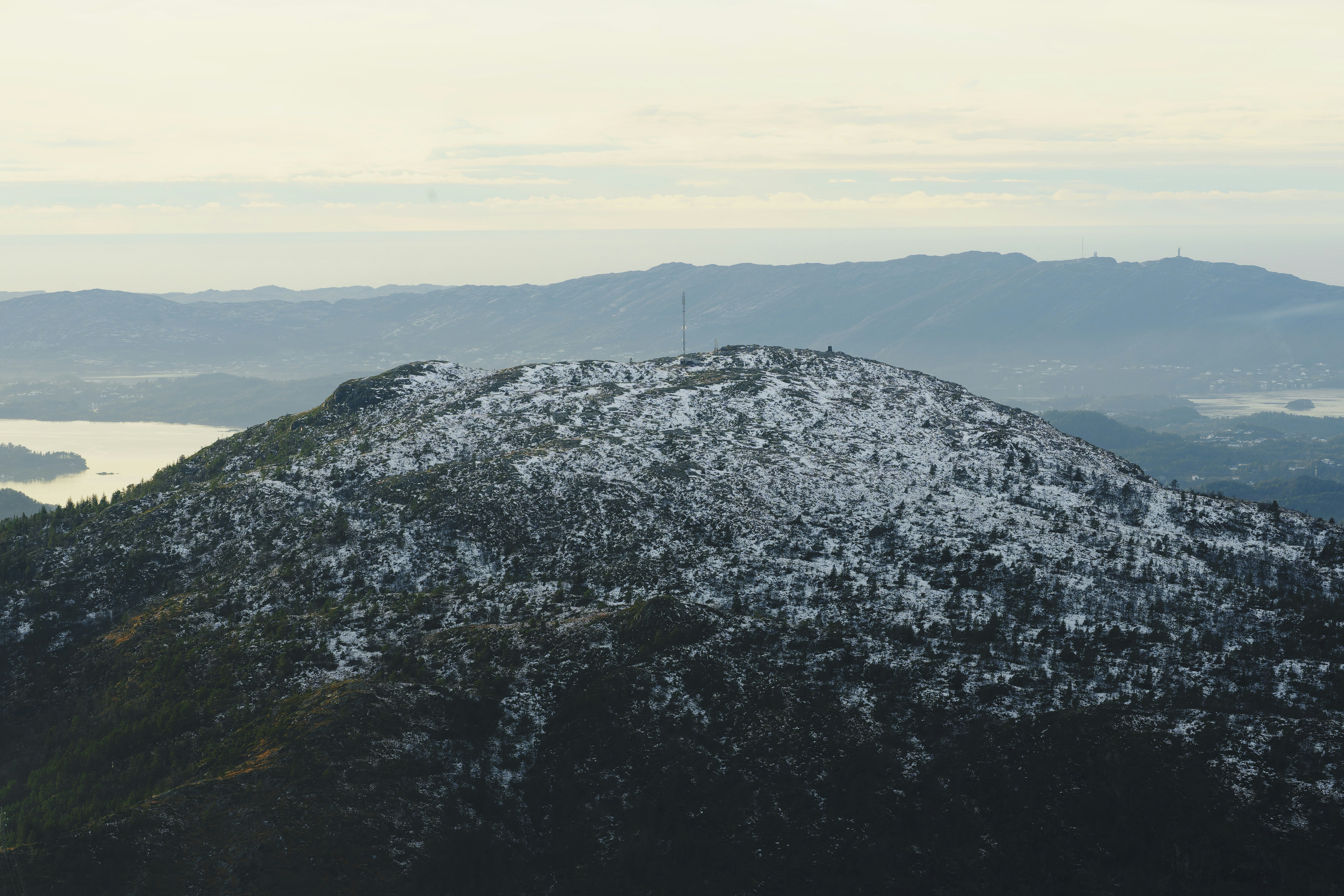 Snow-dusted summit under a calm, expansive sky