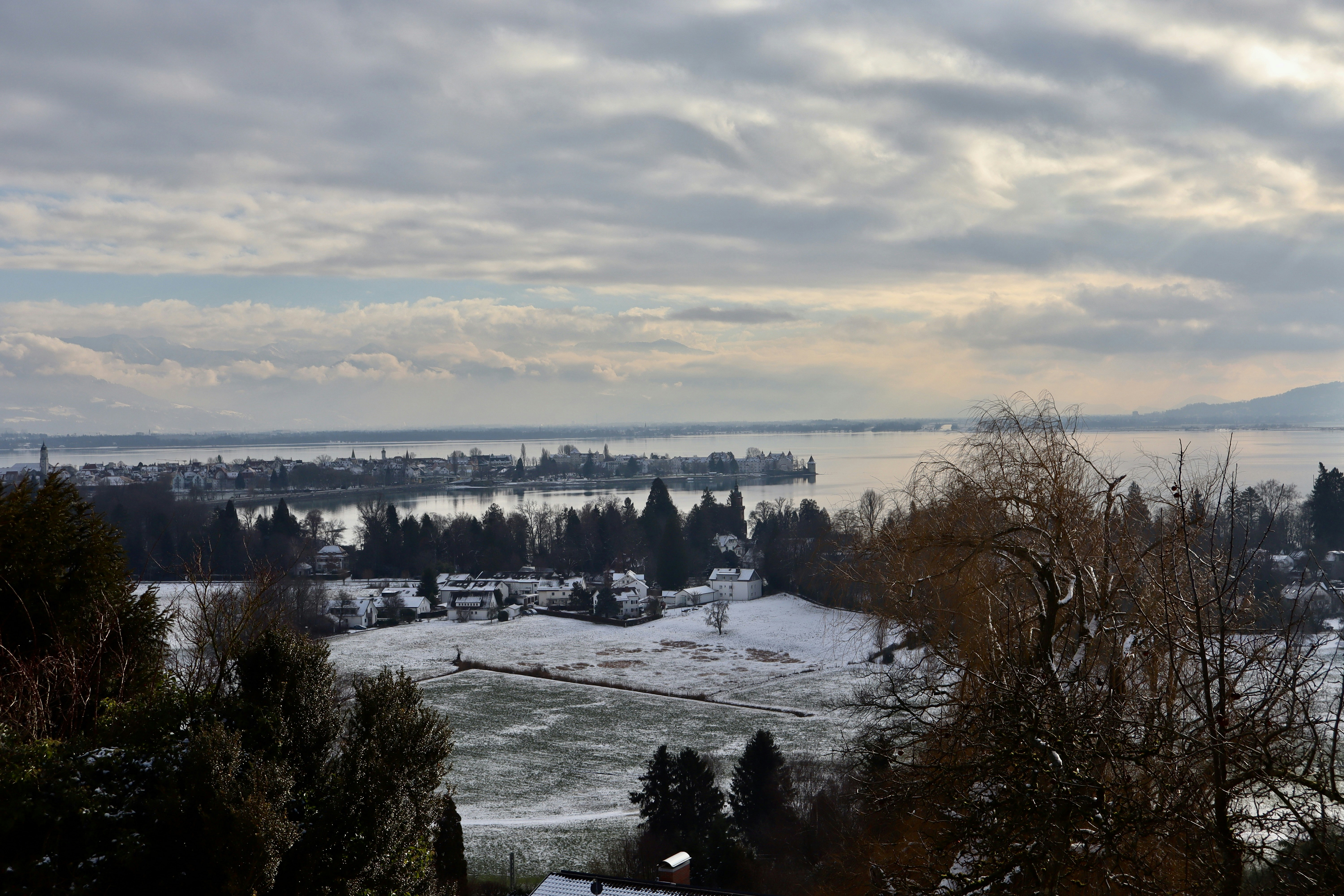 Snow-kissed valley over a quiet lakeside landscape at dusk