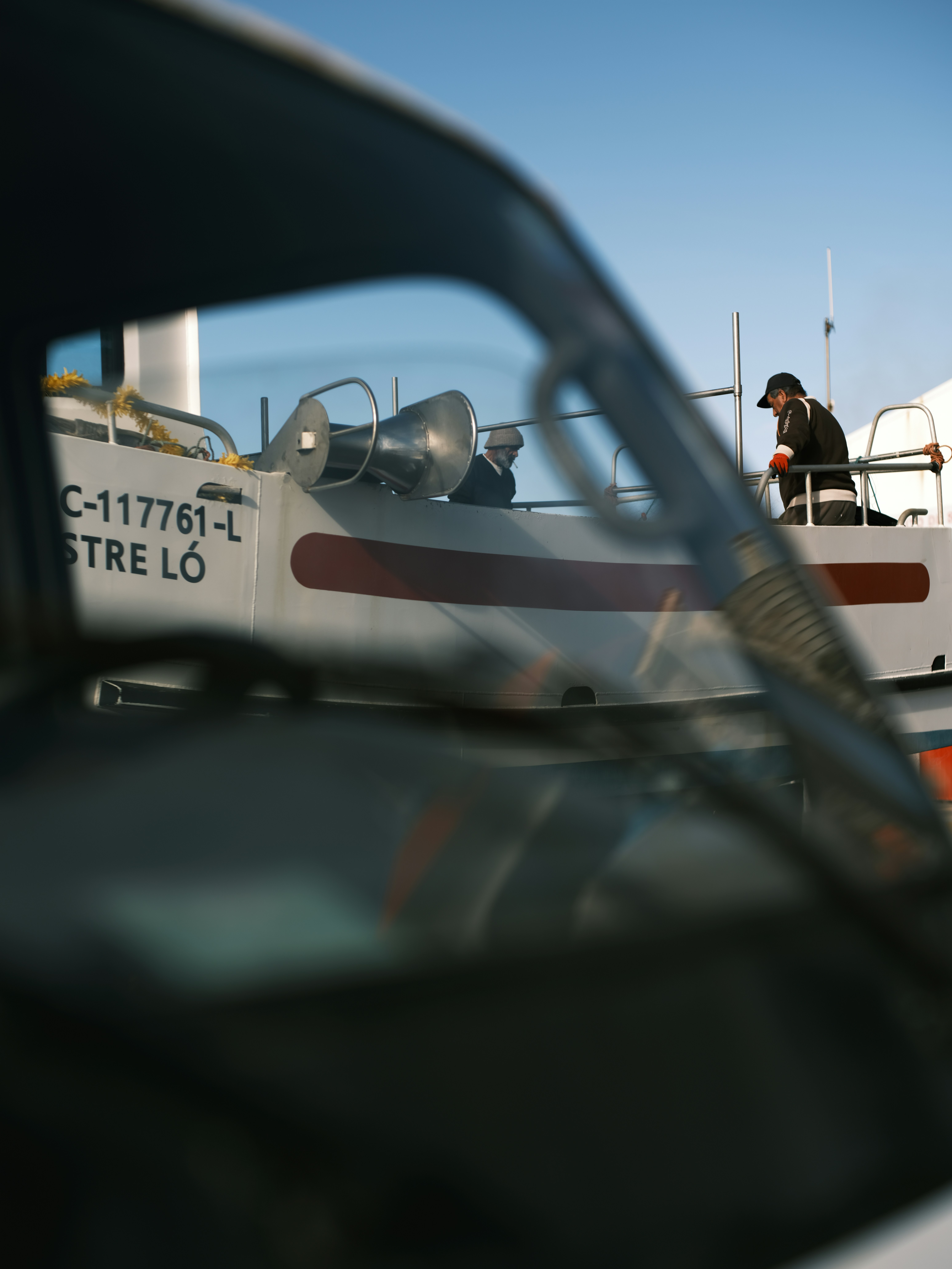 Bridge Crew at Distant Deck: a Close Frame through a Foreground Window