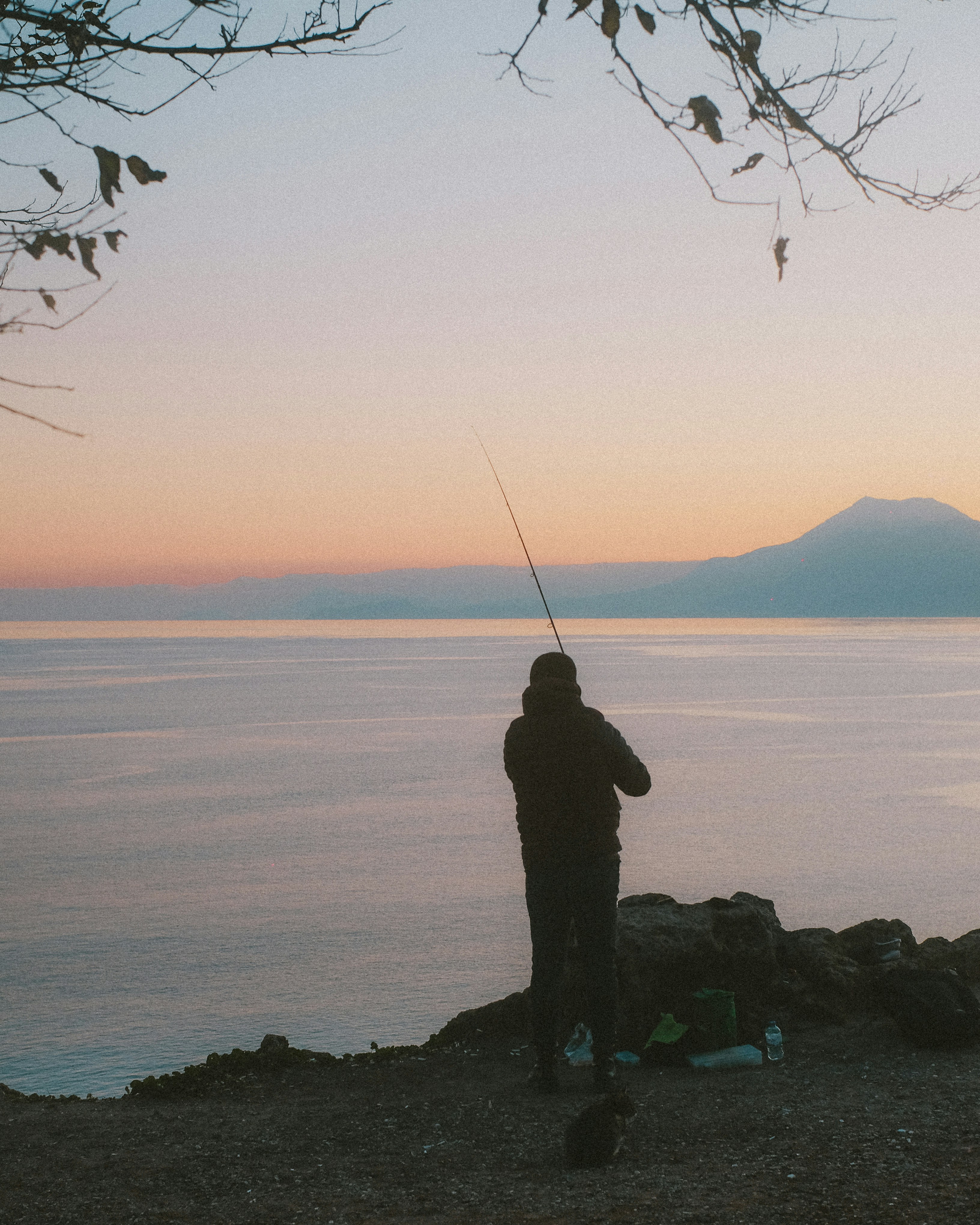 Silhouette by the Sea: A Quiet Moment of Casting at Sunset